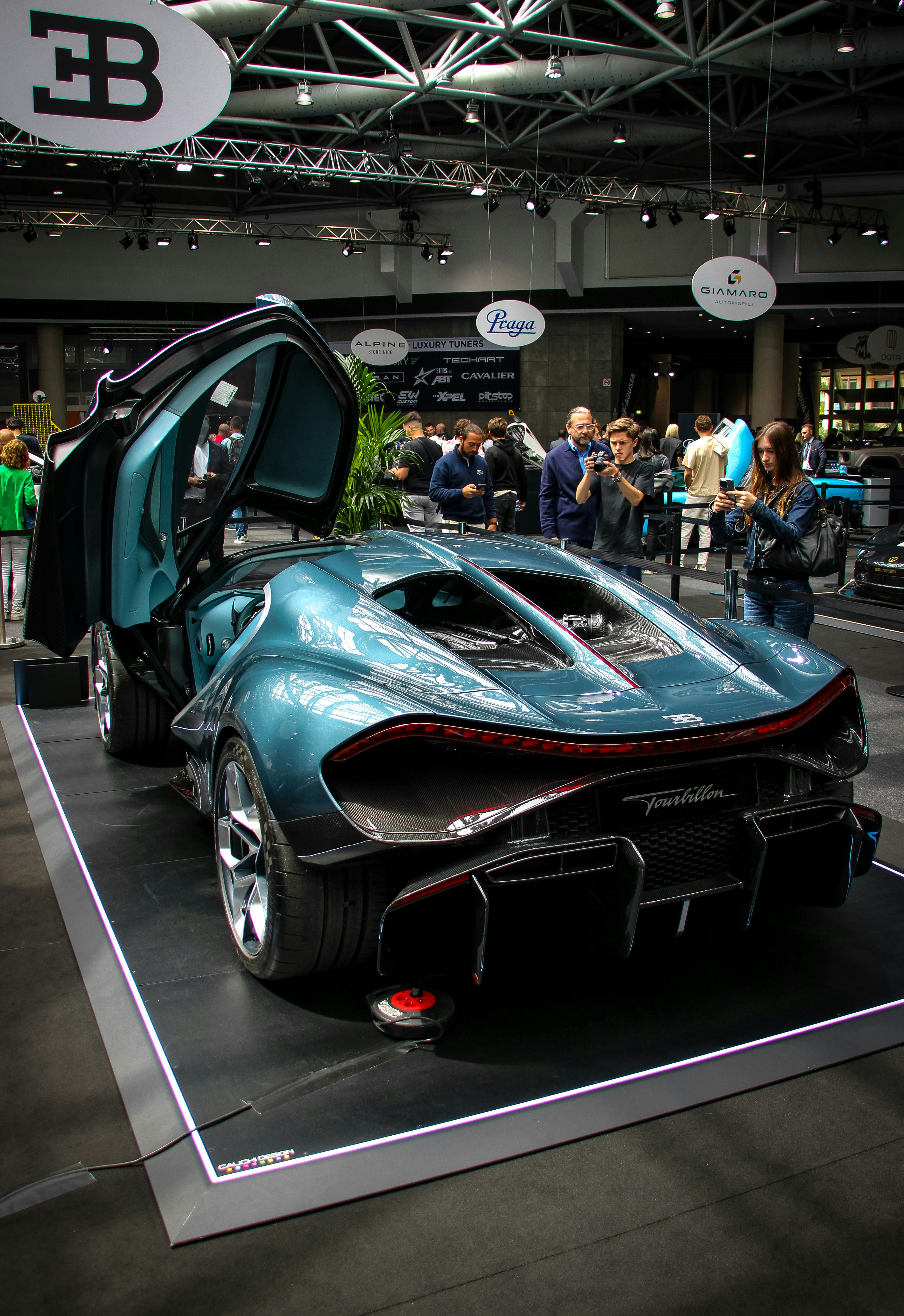 A Teal Hypercar Under Exhibition Lights