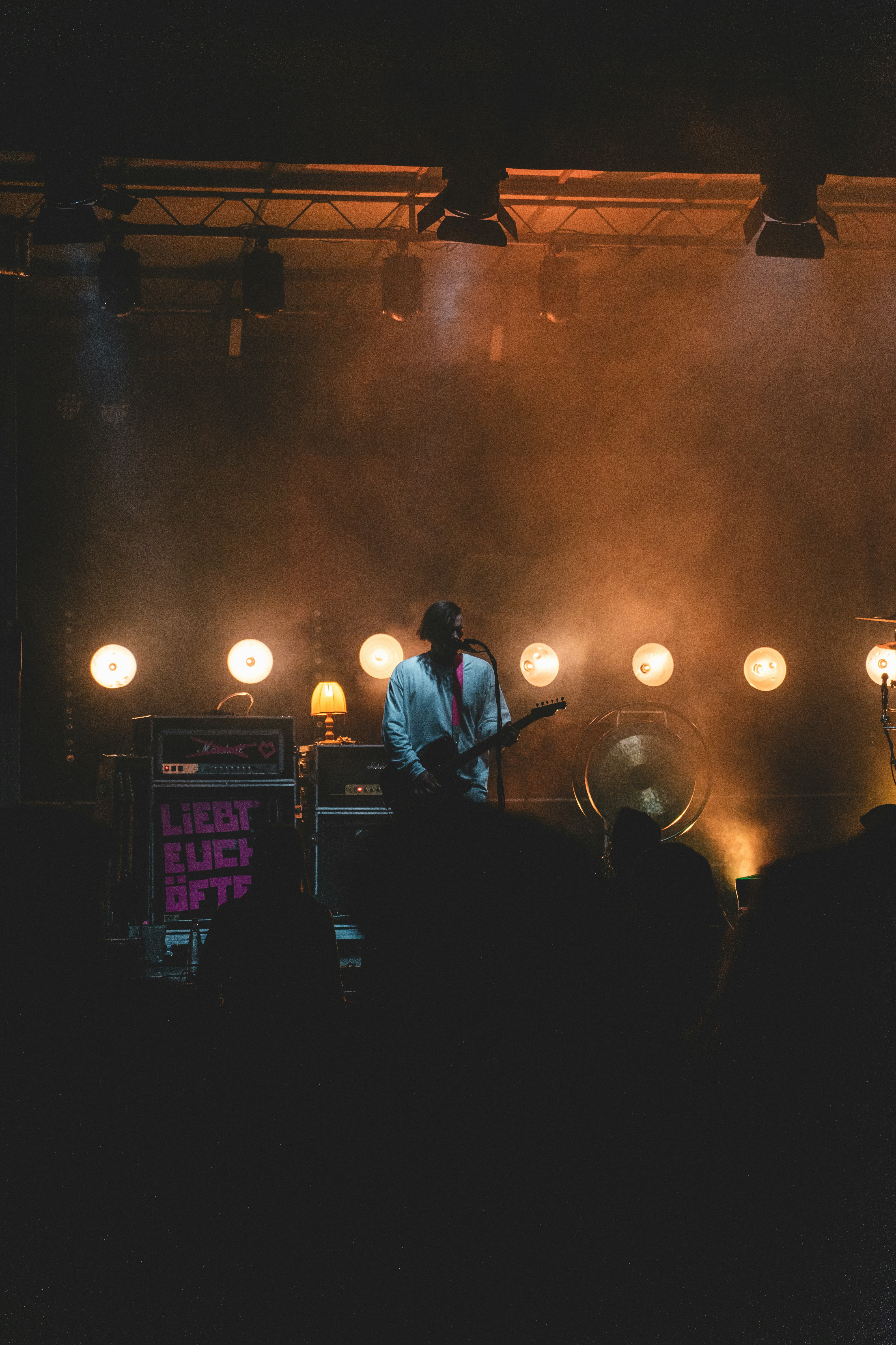 Midnight Grit: The Lone Guitarist in Warm Stage Haze