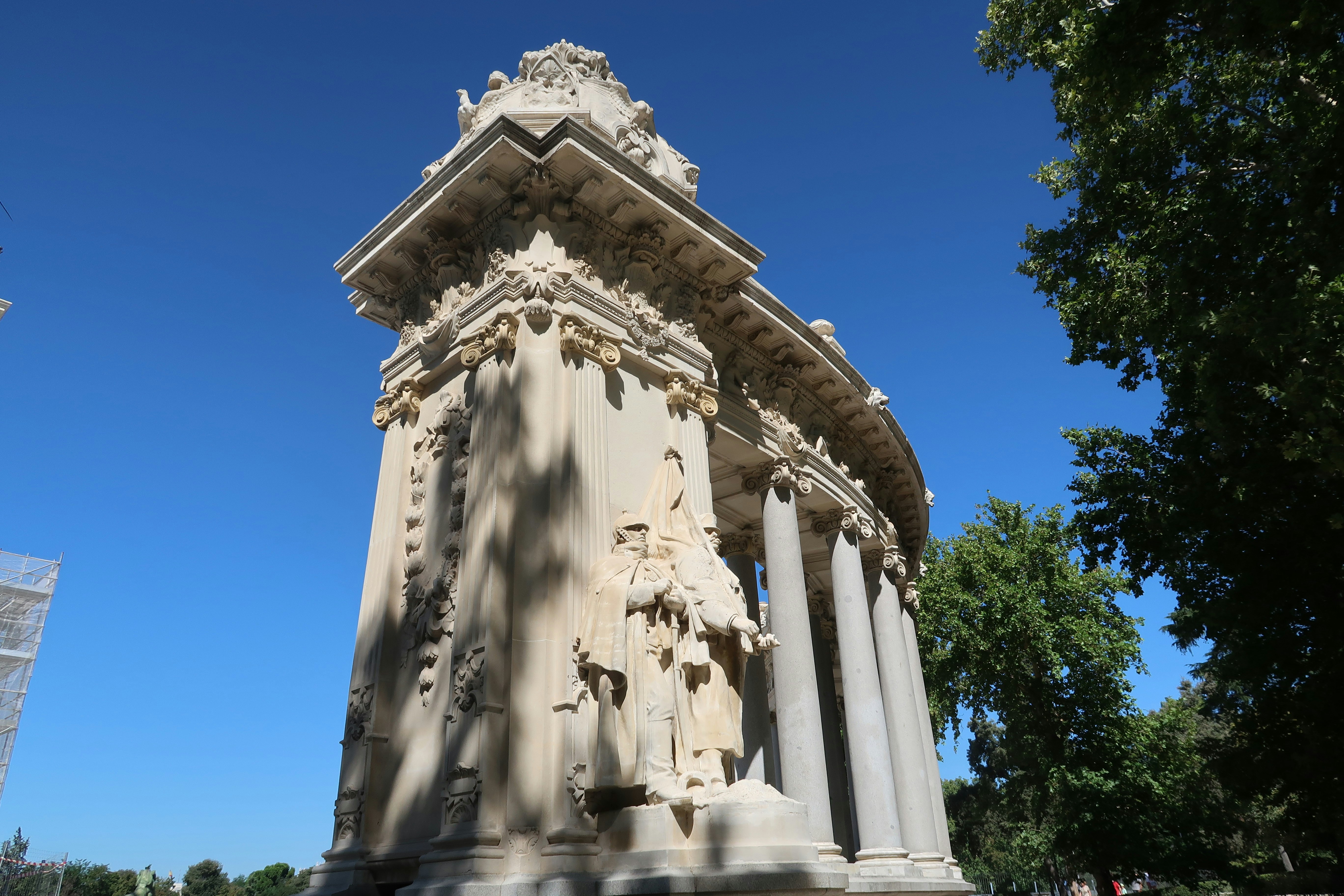 Stone Monument Under a Clear Blue Sky with Classical Sculptures