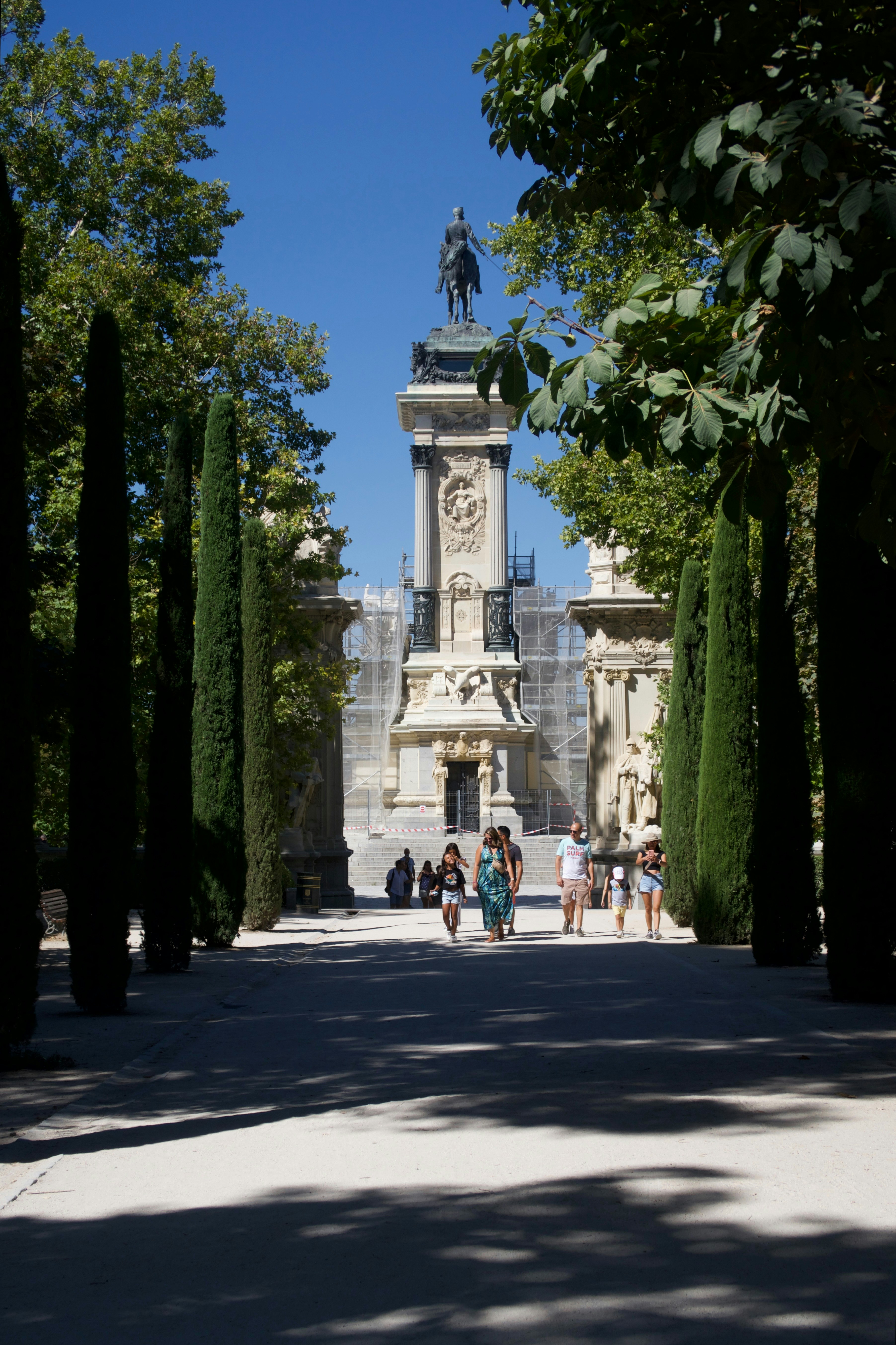 Equestrian Monument Framed by Tall Cypresses in a Sunlit Plaza