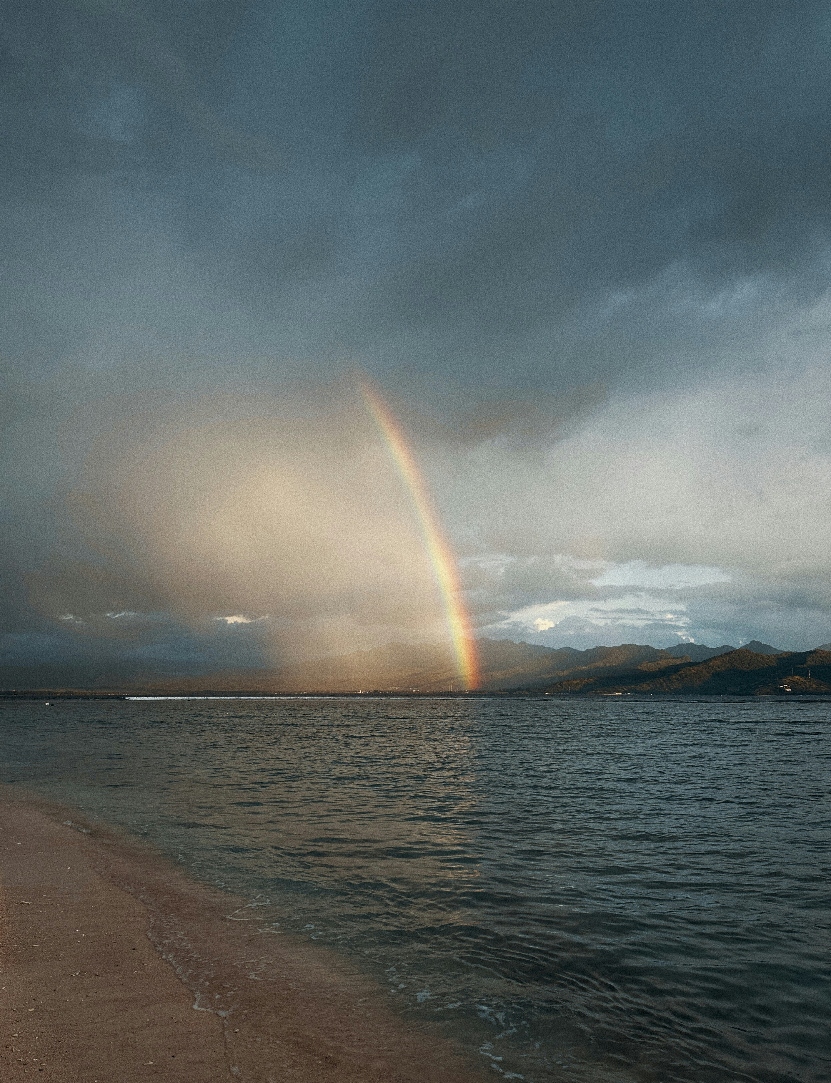 Rainbow on the Sea: Dawn Over Gentle Waves