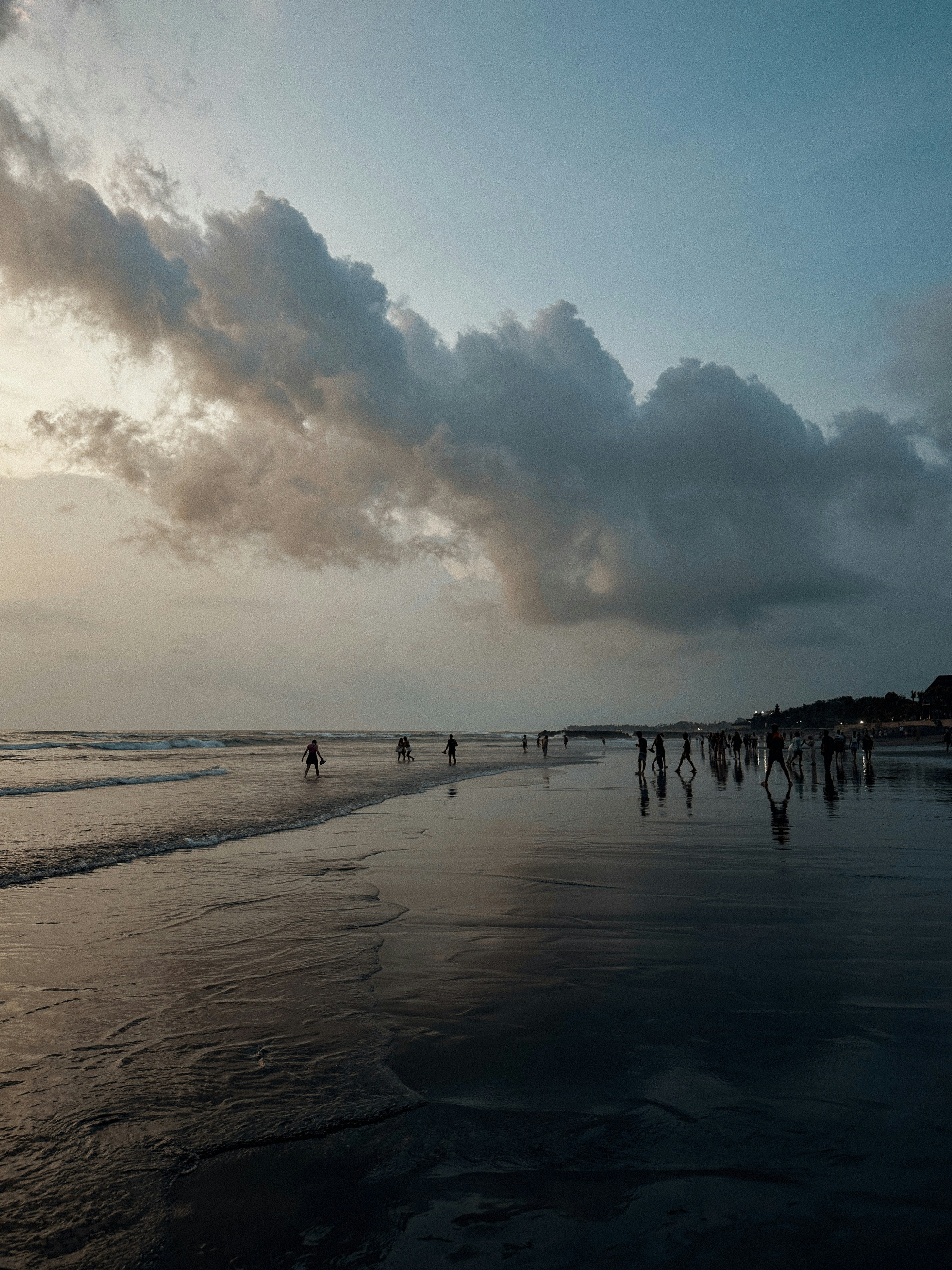Sunlit Crest: People on a Quiet Atlantic Shore at Dusk