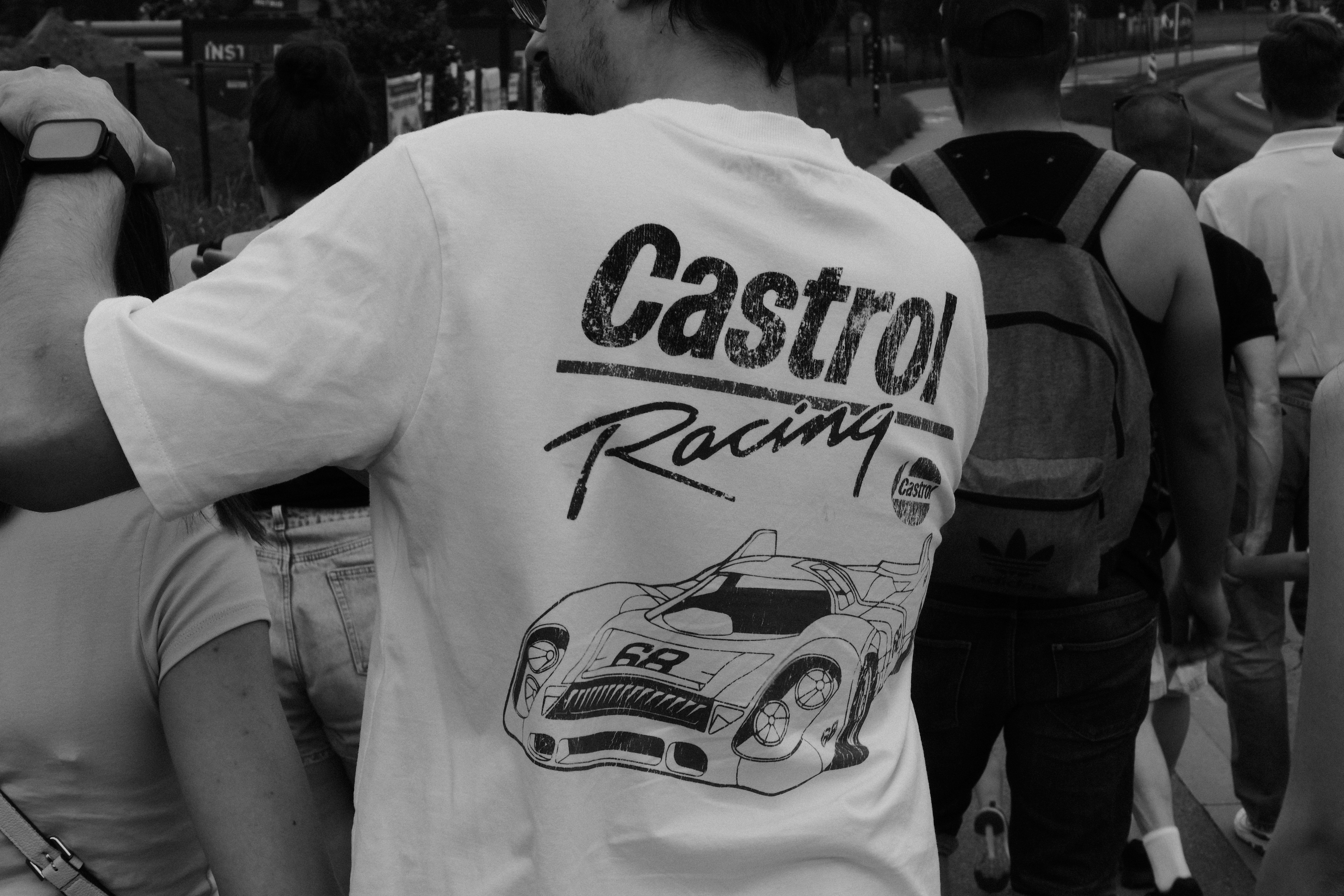 Rear View of a Car-Themed T-Shirt in a Crowded Street
