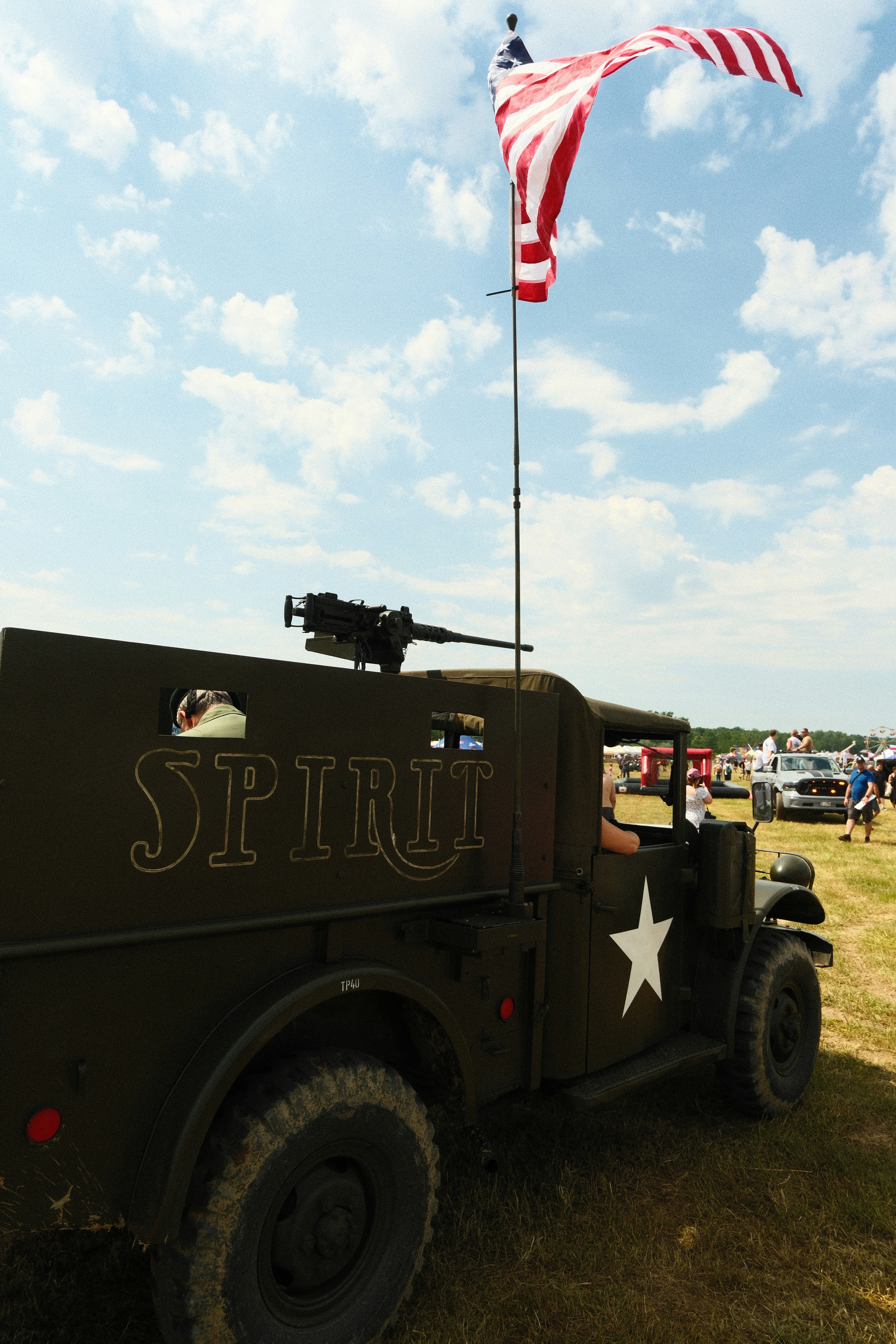 Flags, Wheels, and Spirit: A Military Jeep at the Field Flagpole