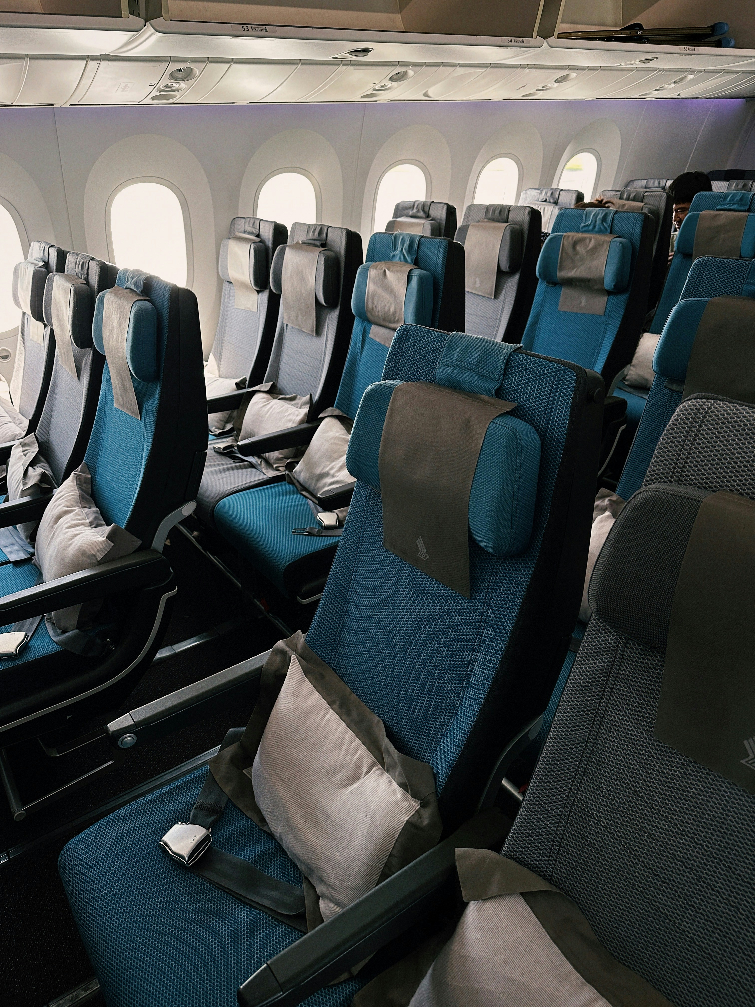 Aisle-View Oasis: Blue Seats and Serene Window Light
