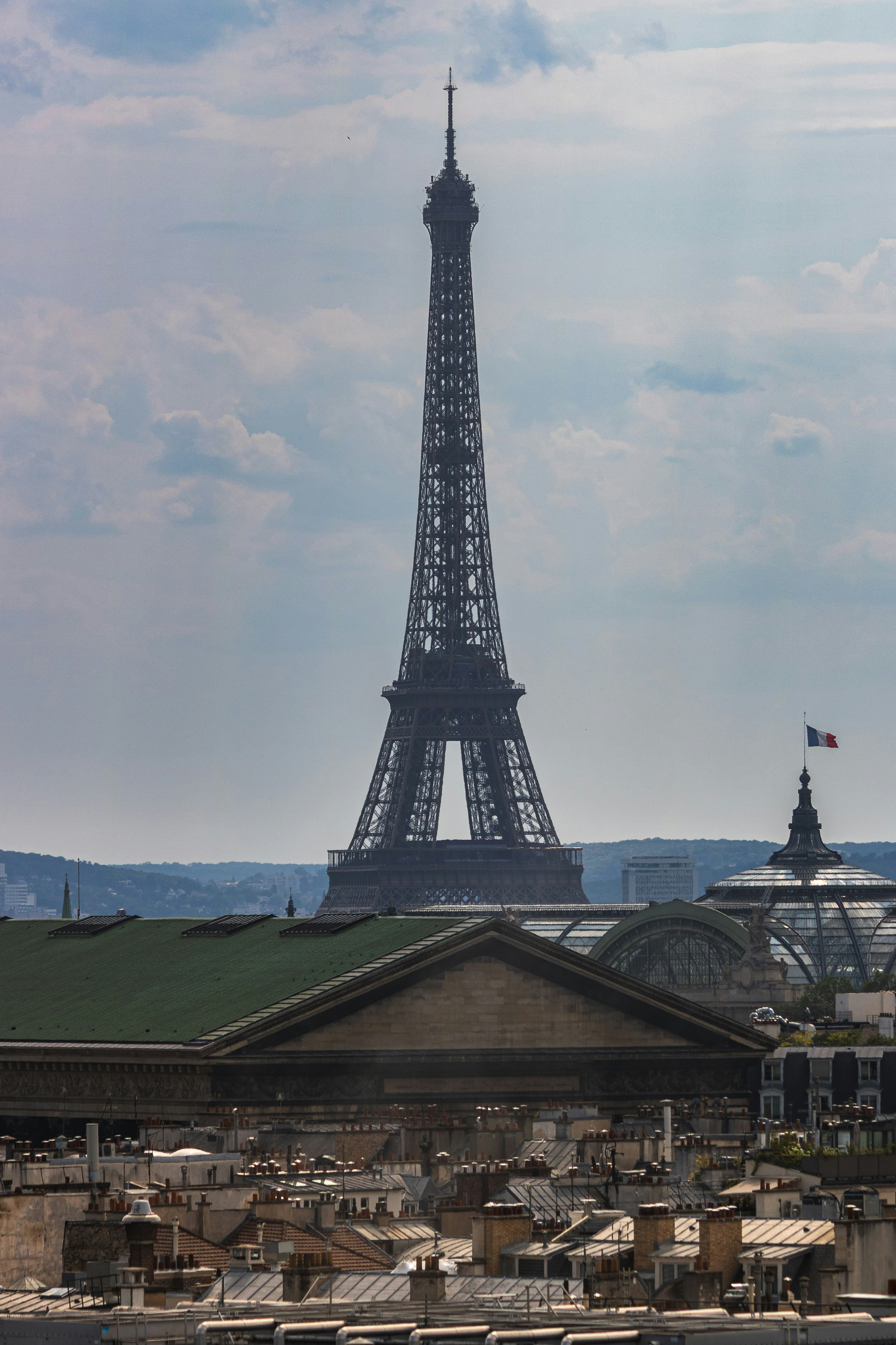 Parisian Skyline Surmise: The Eiffel Tower Above the City Rooftops