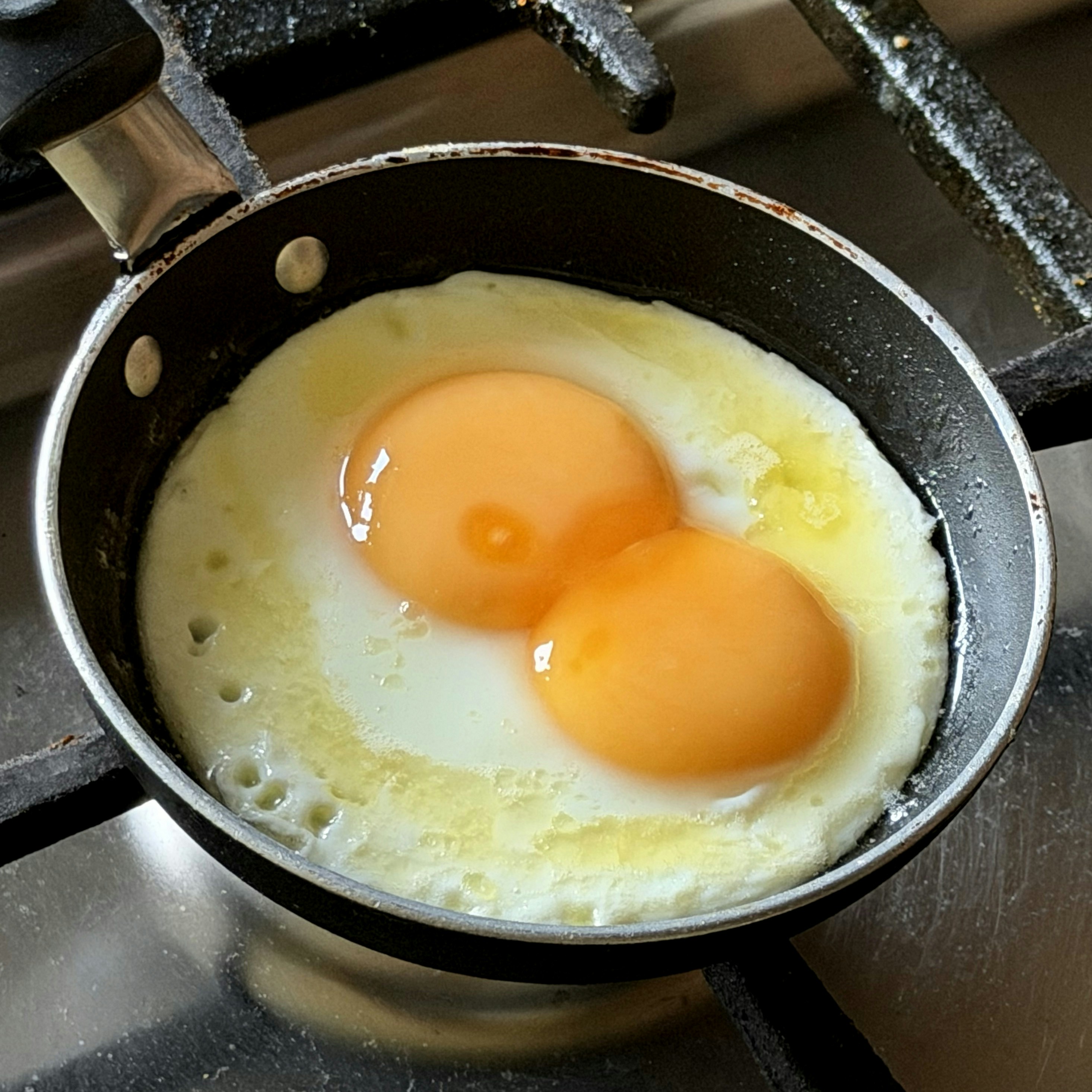Two Sunny Orbs of Breakfast: Eggs Nestled in a Sizzling Pan