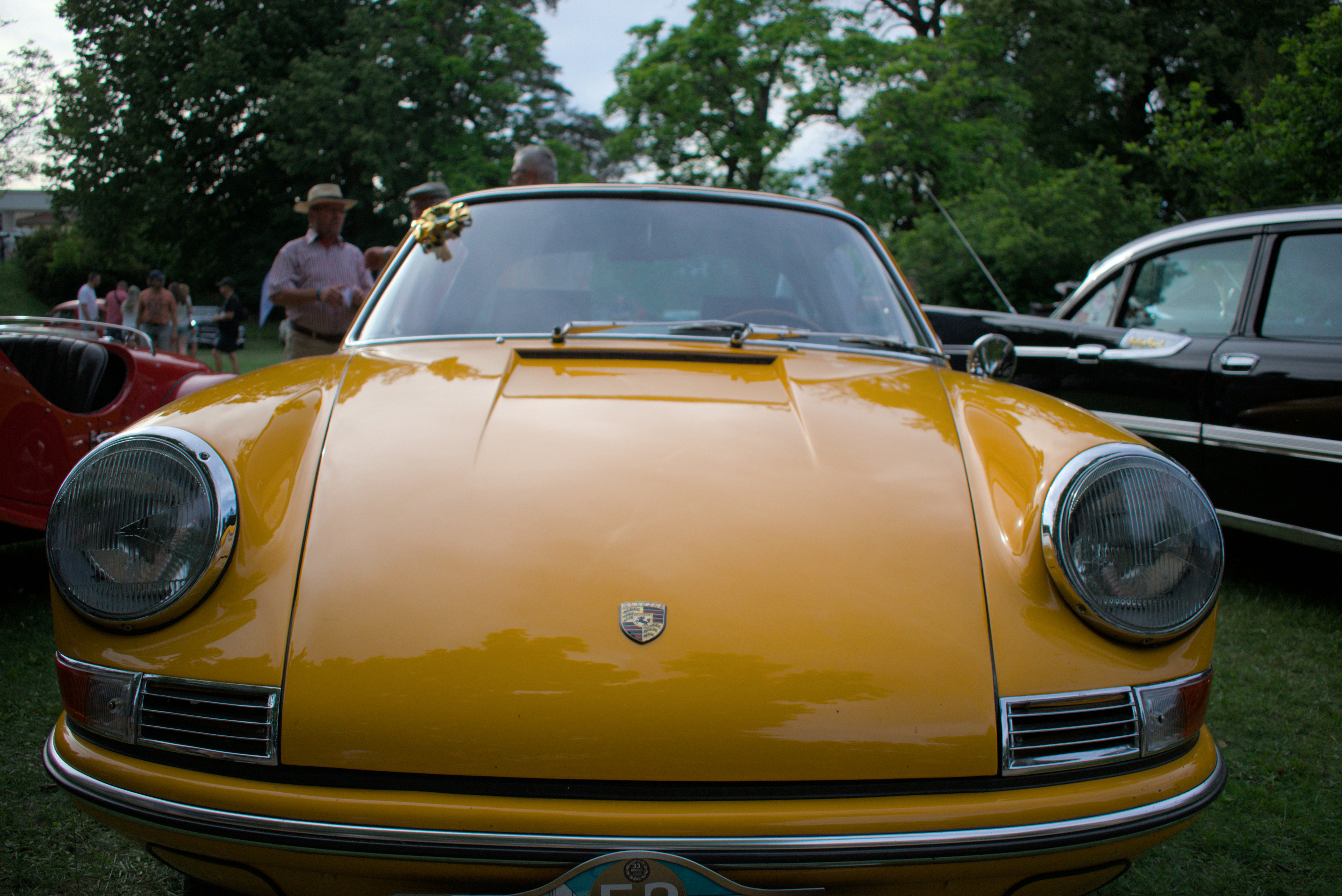 Golden Classic: Front View of a Vintage Porsche at a Car Show