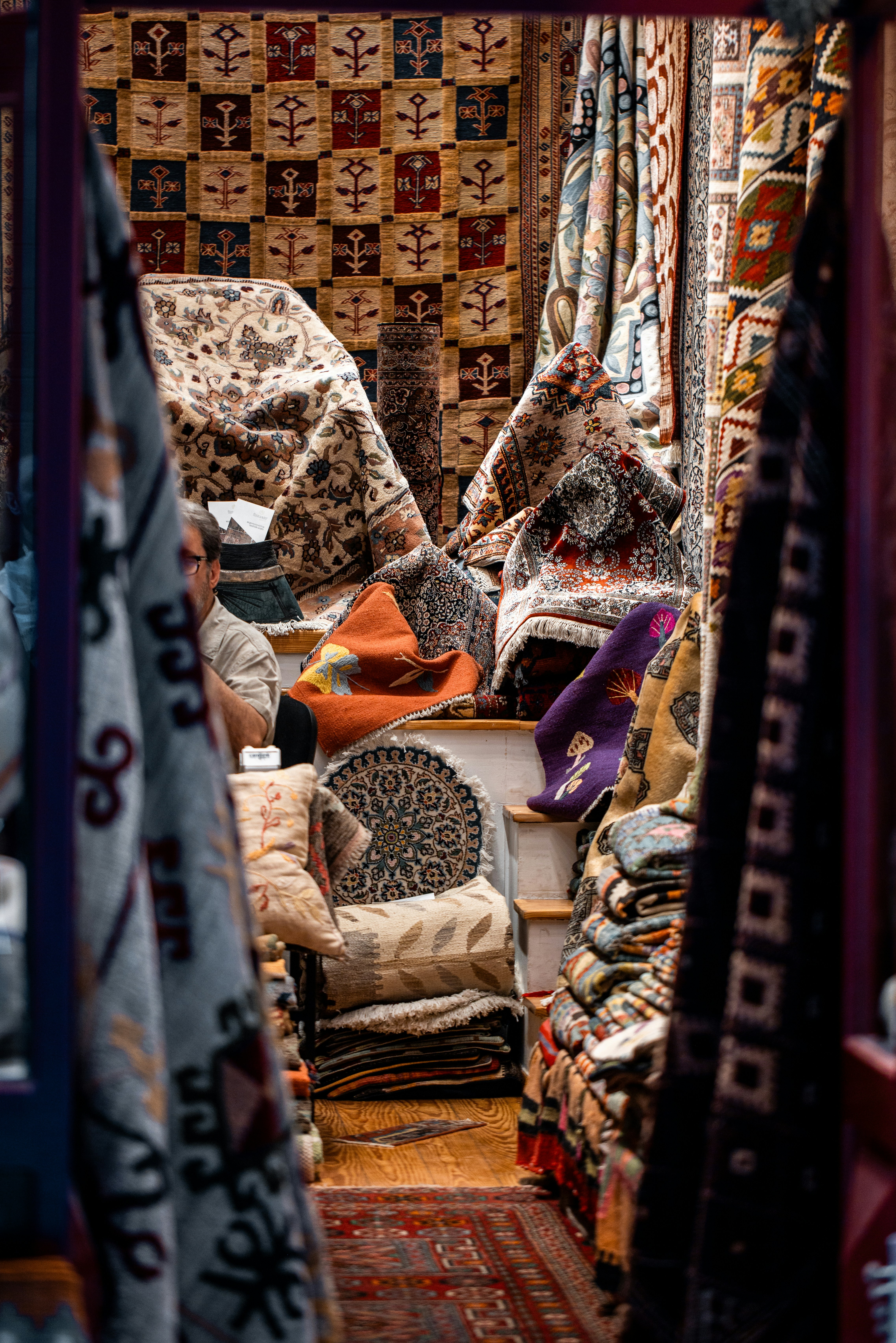 A Textile Haven: Colorful Rugs and Fabrics Framed by Shopfronts