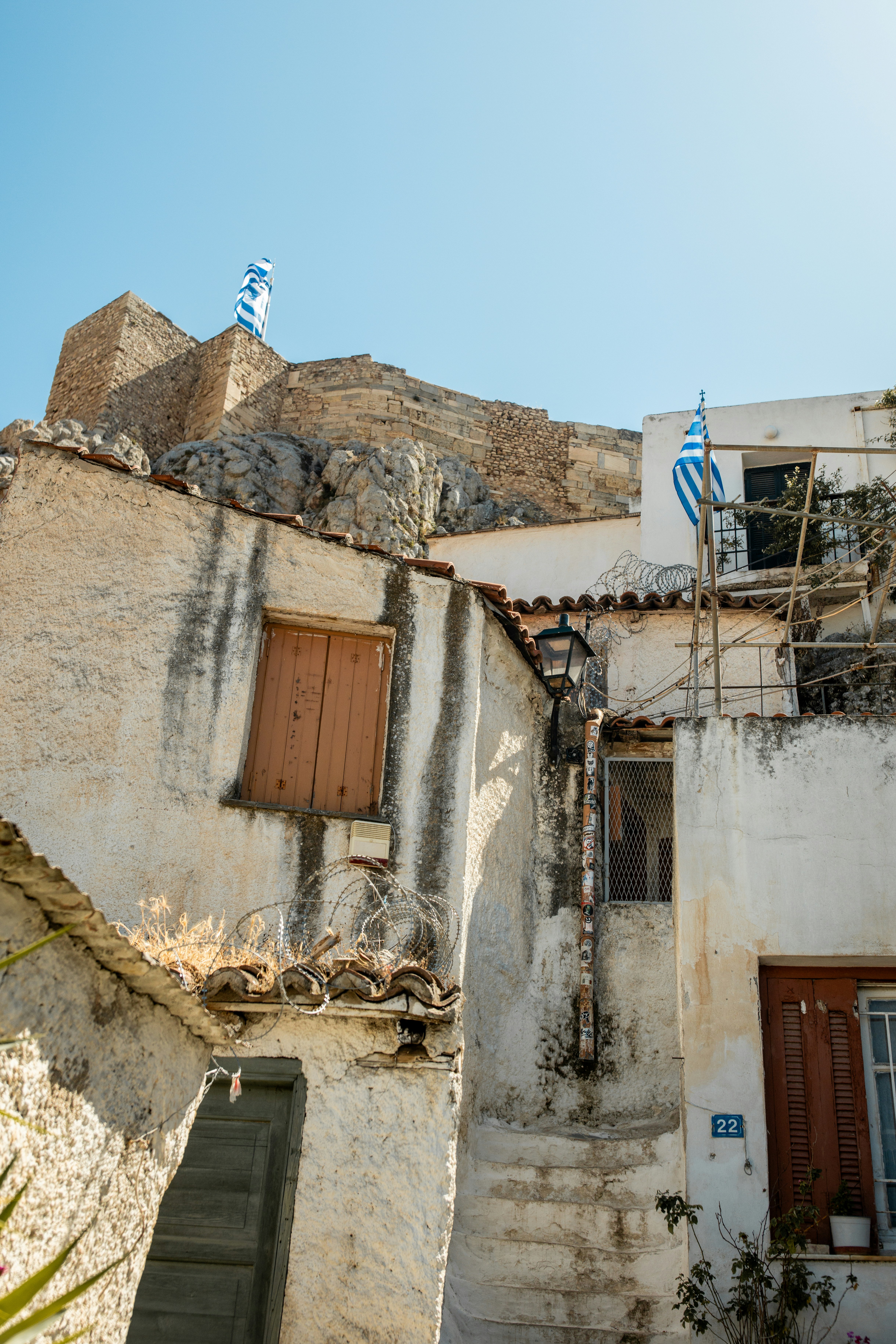 Sunlit Garlands Above Old Stone Walls in a Mediterranean Street