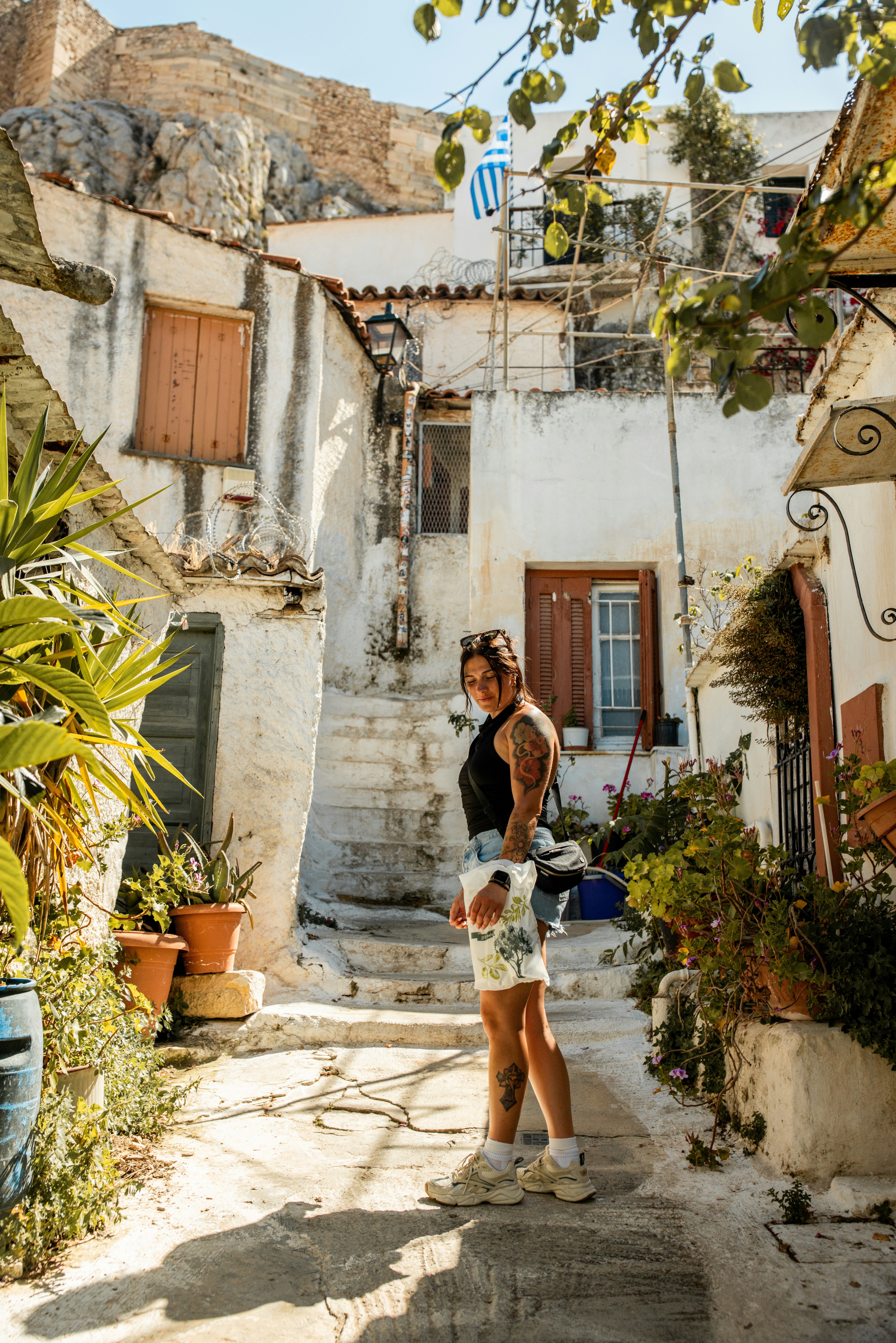 Sunlit wanderer in a sun-dappled alley of whitewashed terraces