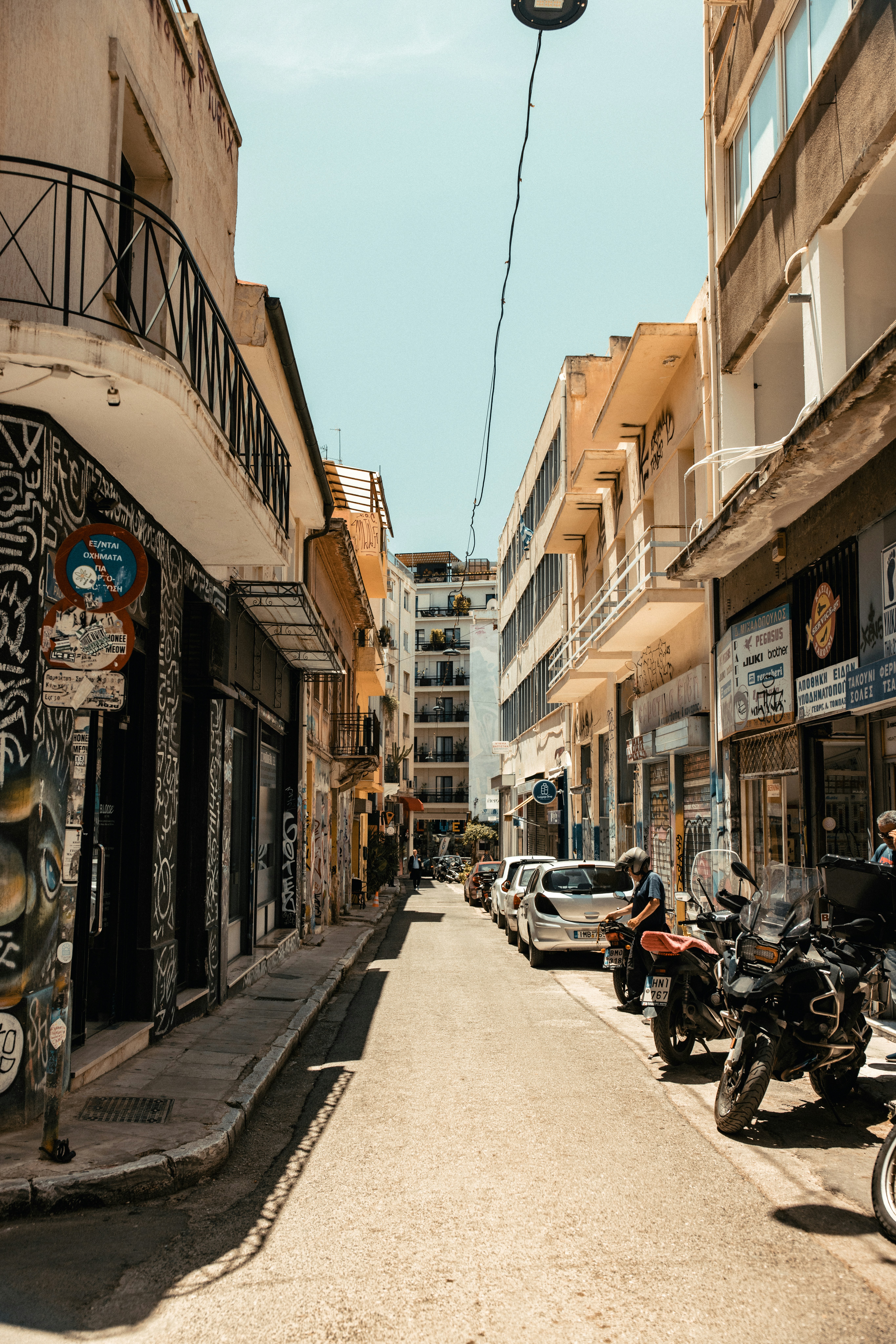 Sunlit Alleyway: Narrow Street Leading to a Distant Horizon