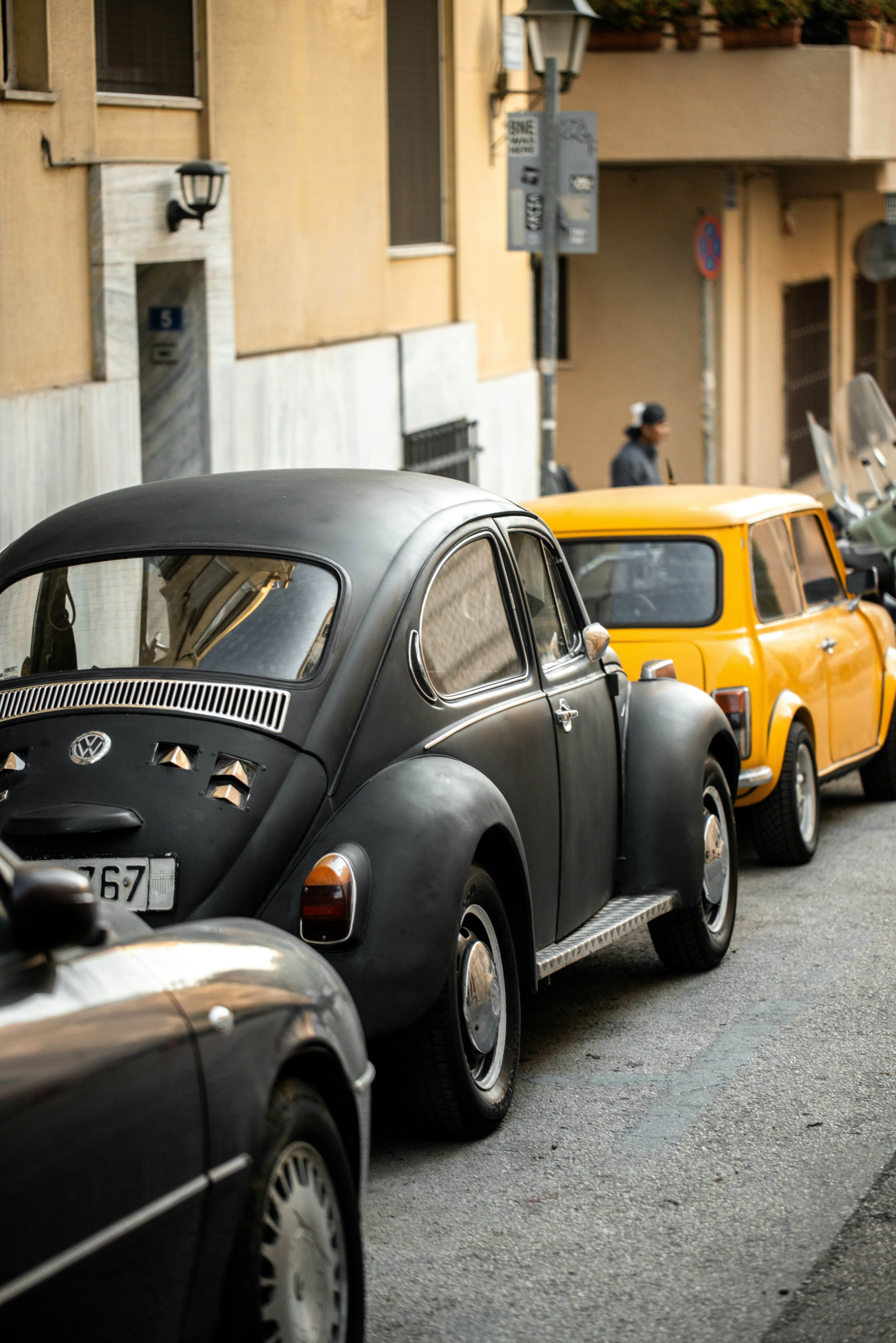 Vintage Parade: A Black Beetle Leading a Yellow Escort