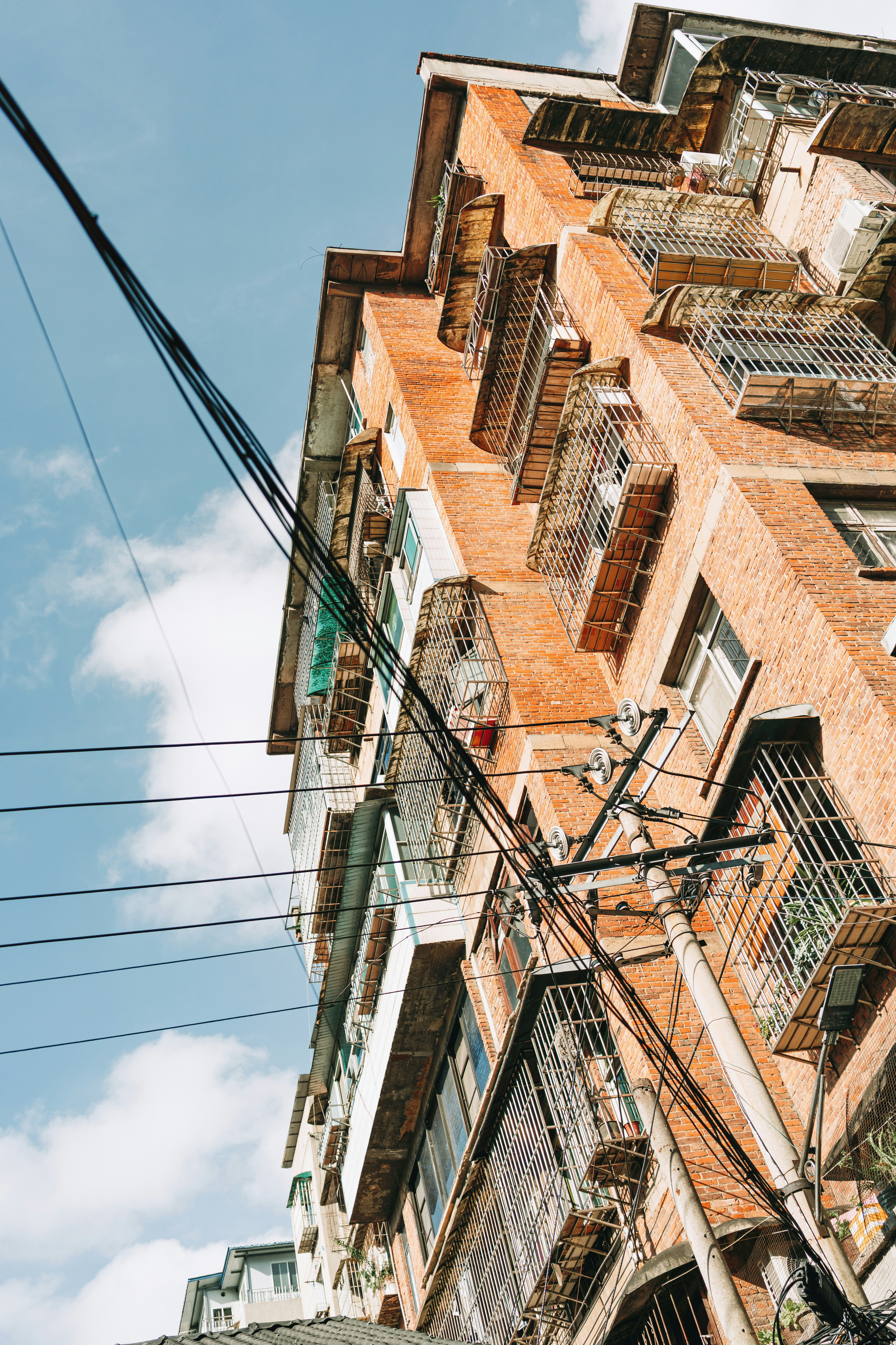 Brick Facade with Exposed Utilities Under a Clear Sky