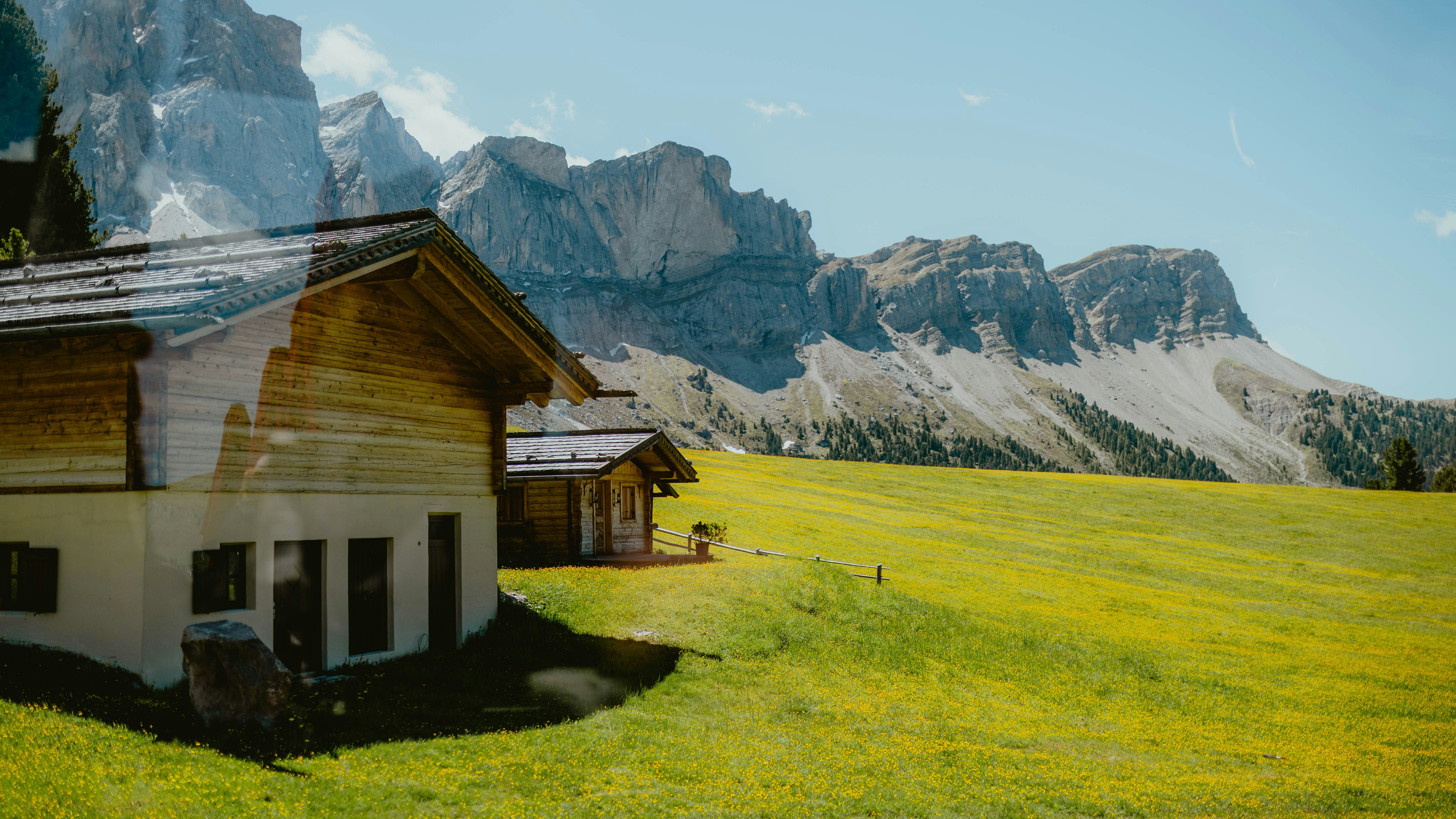 Sunny Alpine Cabin Beneath Jagged Peaks