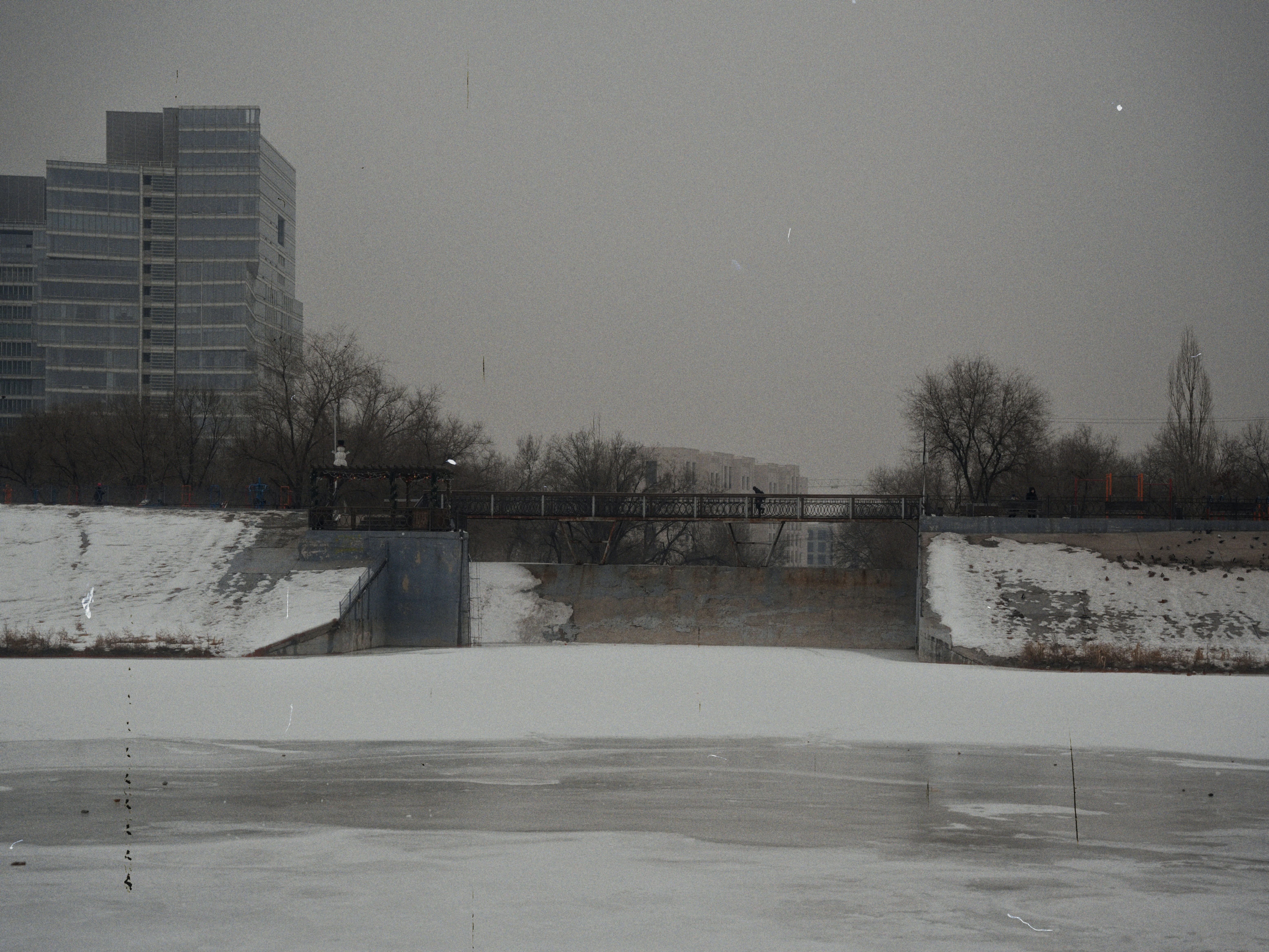 Snow-Capped Spillway Under a Quiet City Arc