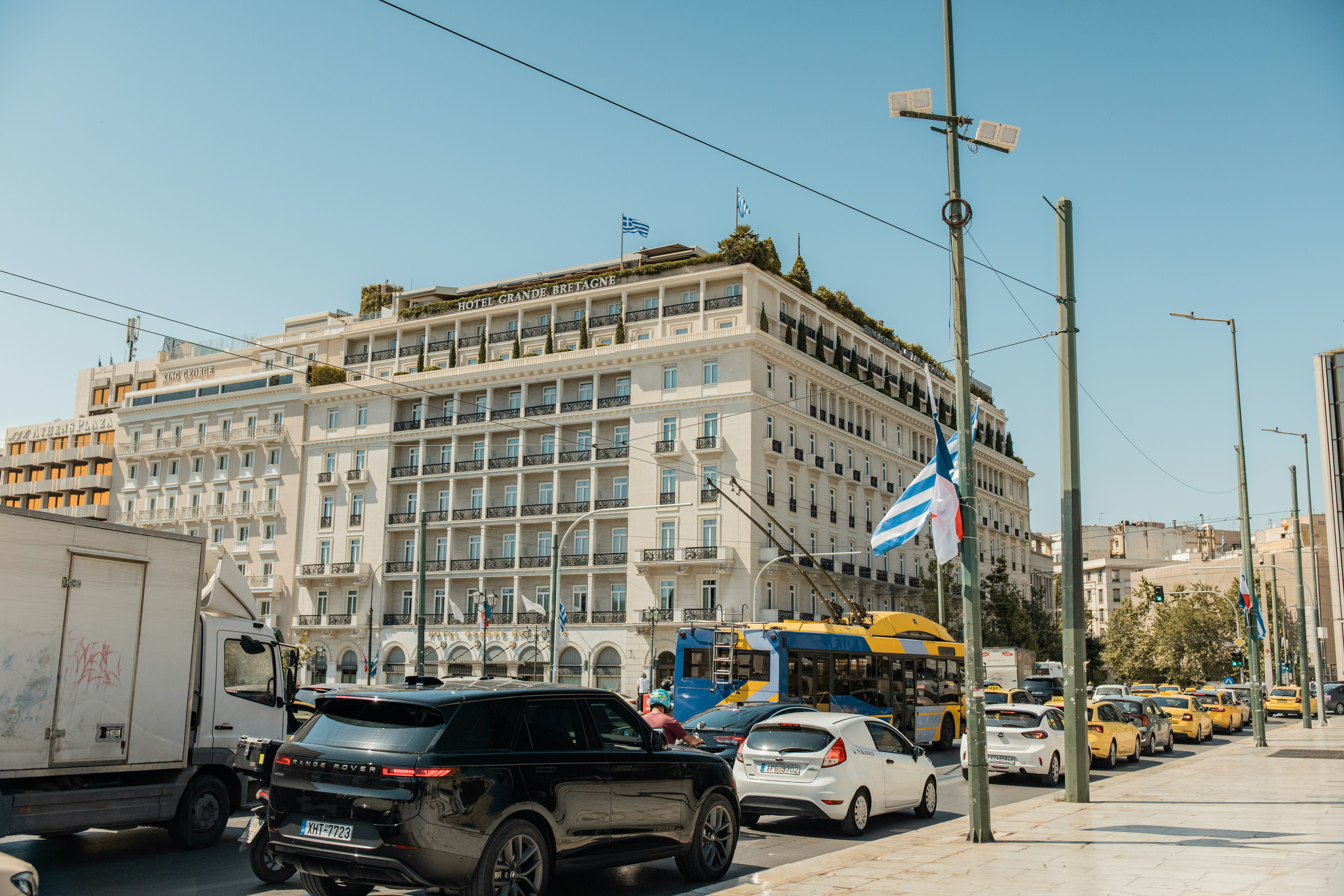 City Street Pulse: A Sunlit Boulevard of Cars and Classical Architecture