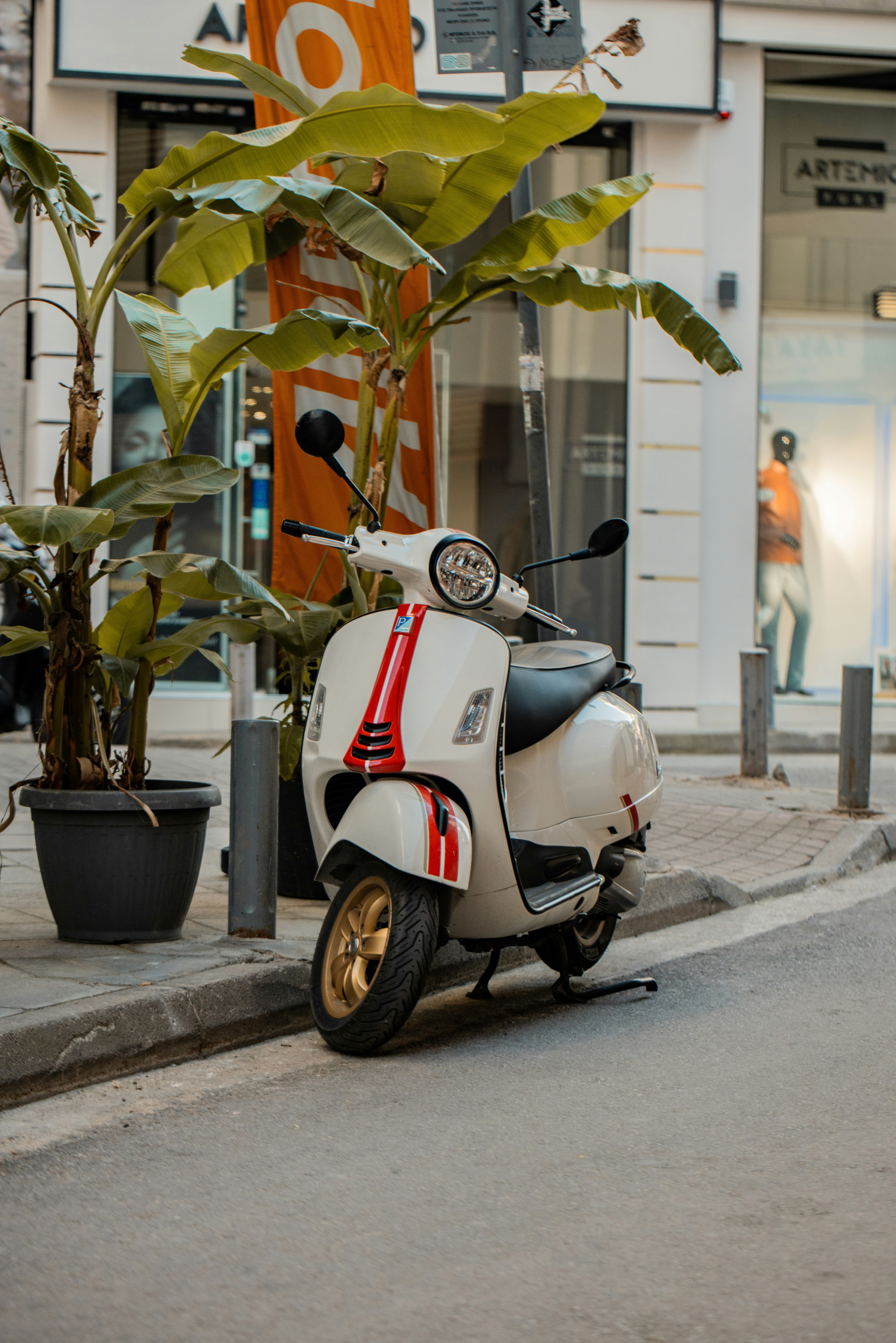 Vintage scooter in urban storefronts with tropical plants