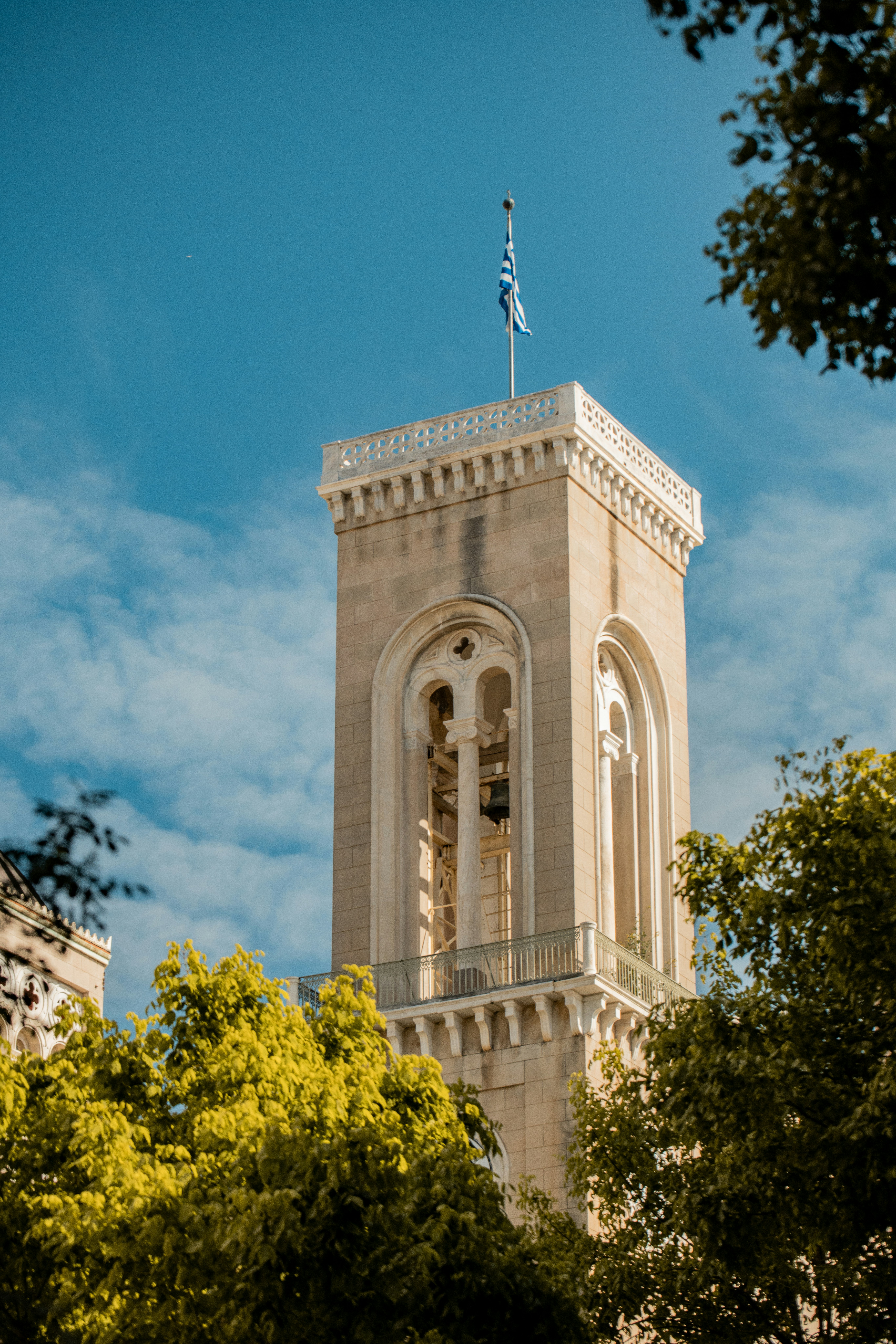 Tower with Flag: A Sunlit Bell Tower Reaches Toward a Clear Sky