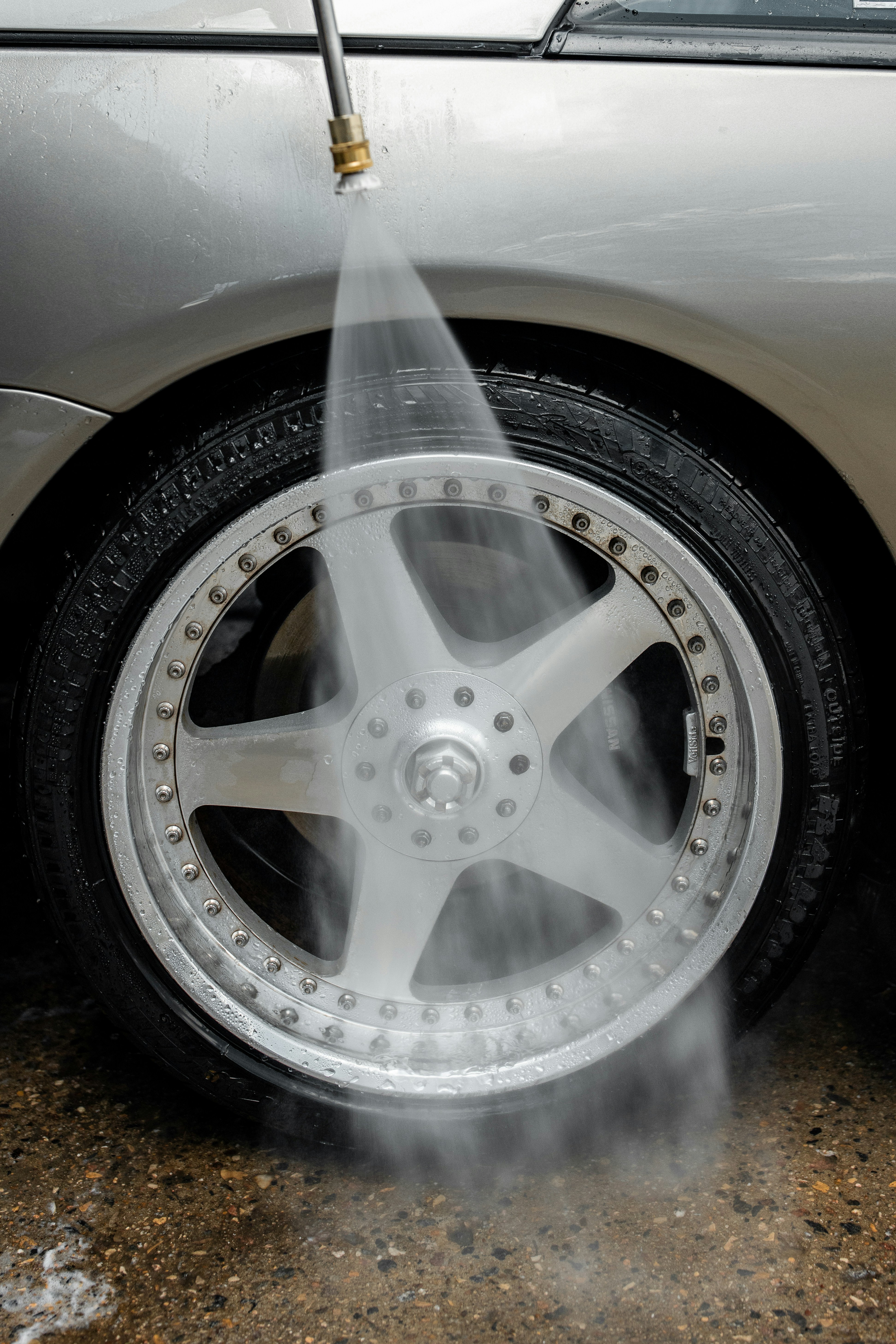 High-Pressure Car Wash Crest: Shimmering Wheel Under Vapor