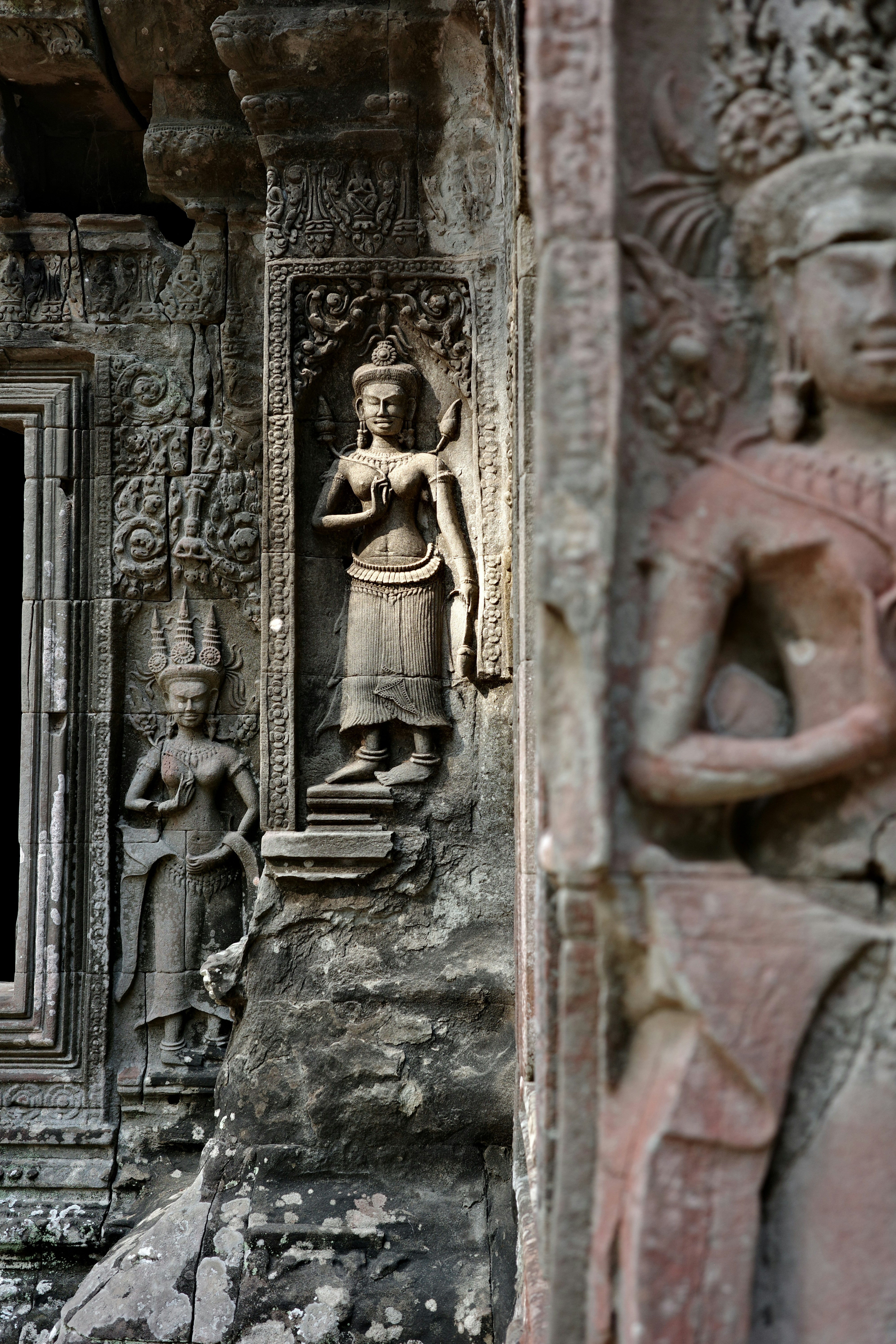 Carved Sentinel: A Buddha-like Standing Figure Emerges from Stone Frieze