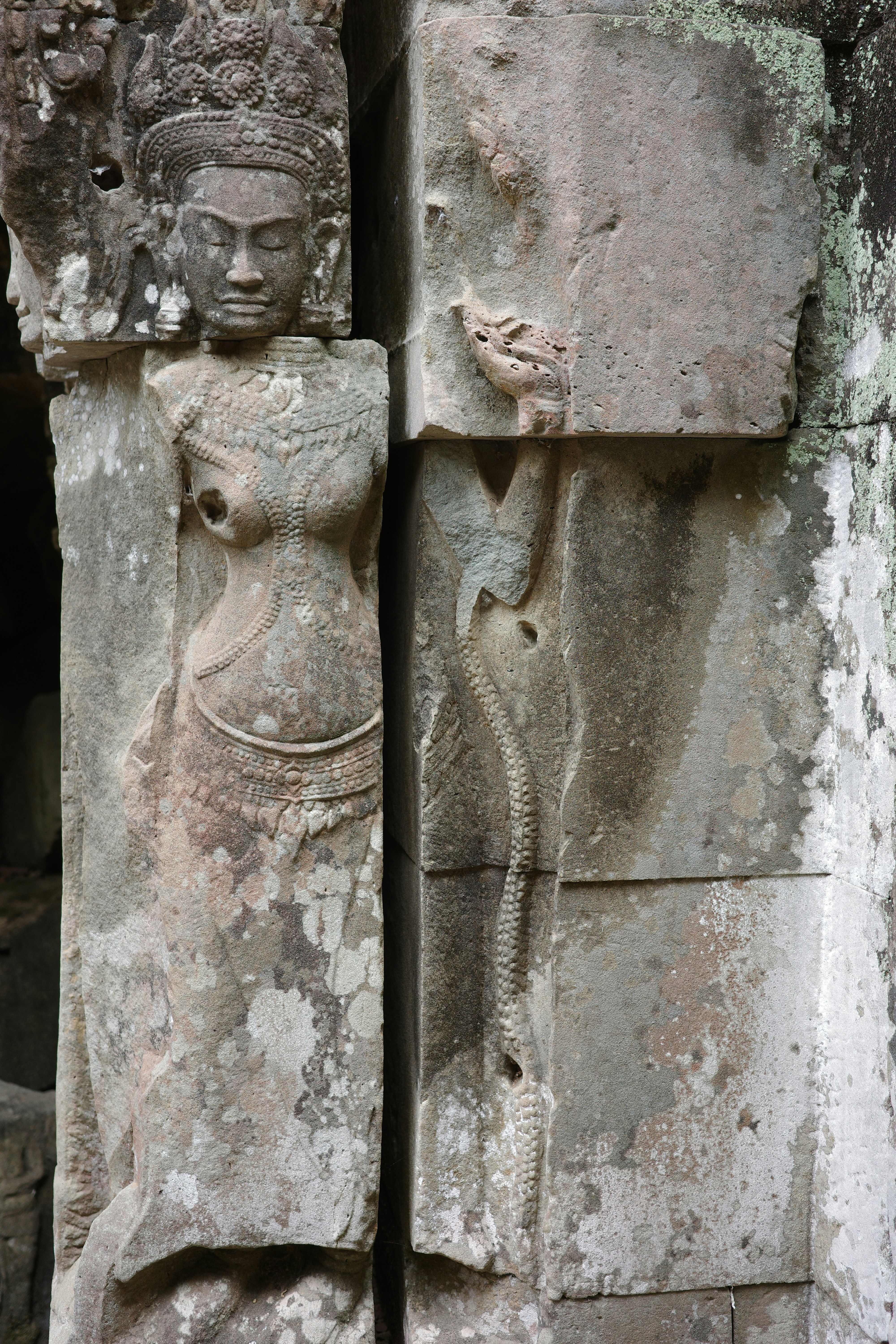 Carved Guardian in Dusk: A Weathered Stone Figure Between Slender Columns