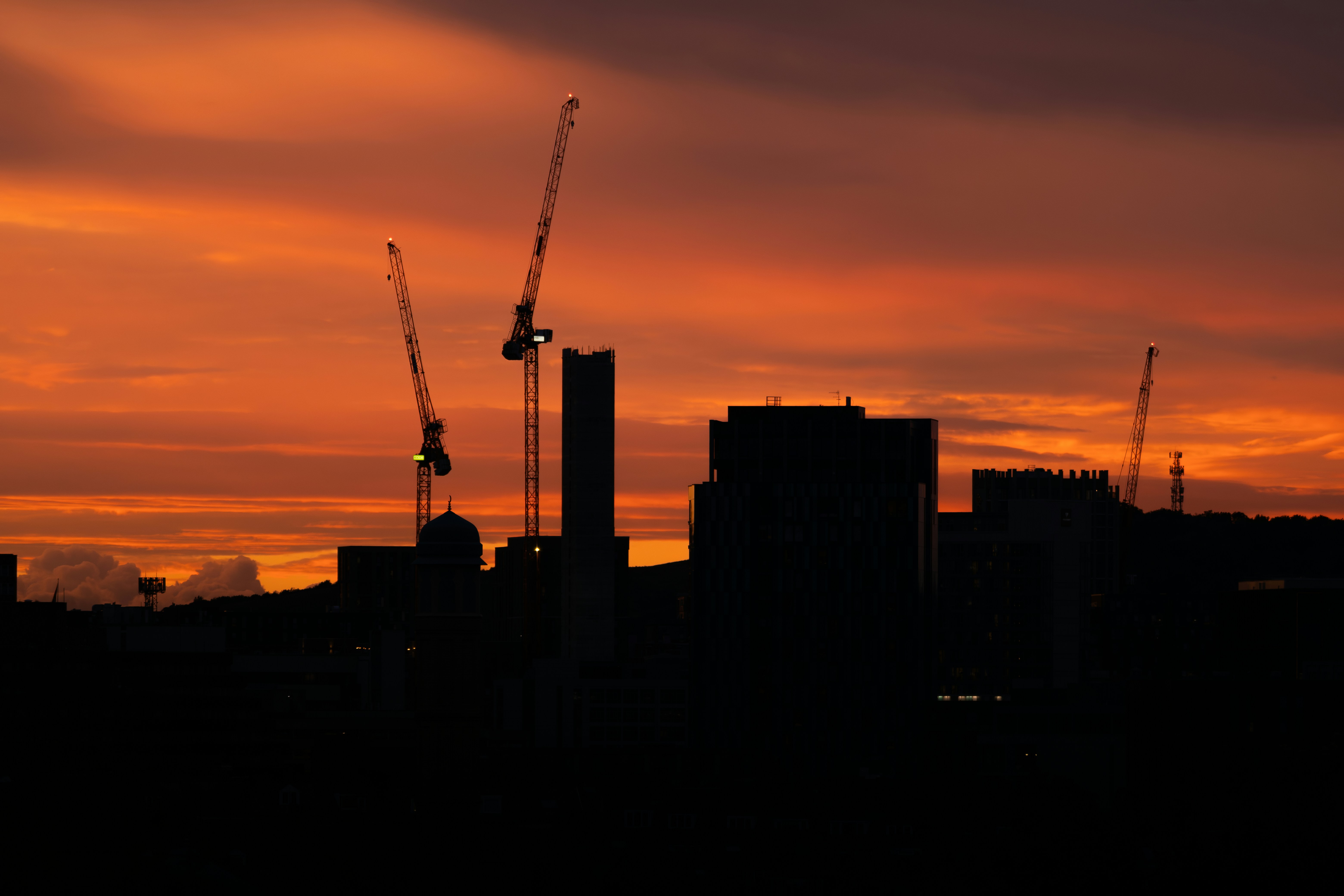 Crimson Dusk Over the Crane-dotted Cityscape