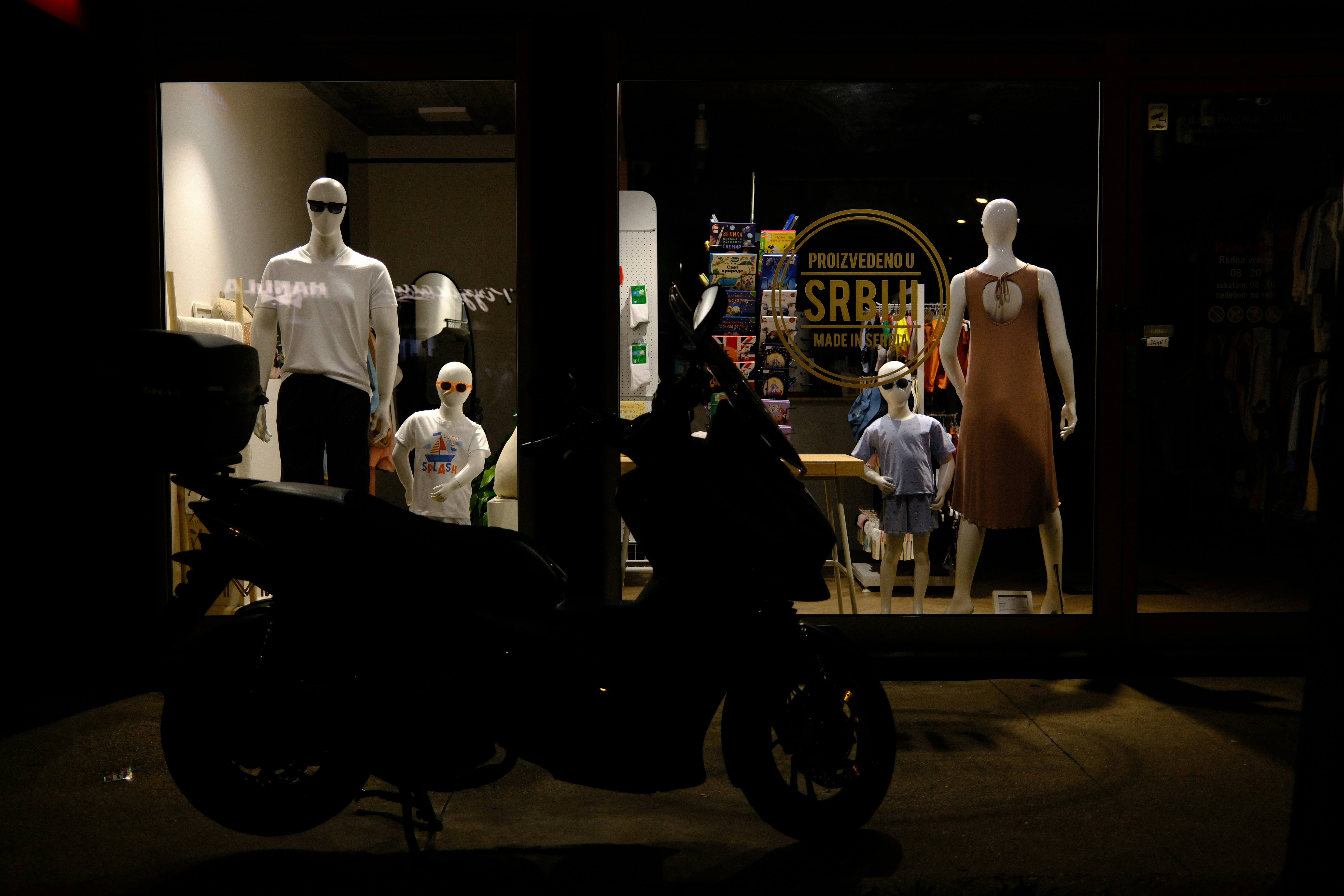 Midnight Fashion Window: mannequins and motorcycle silhouette