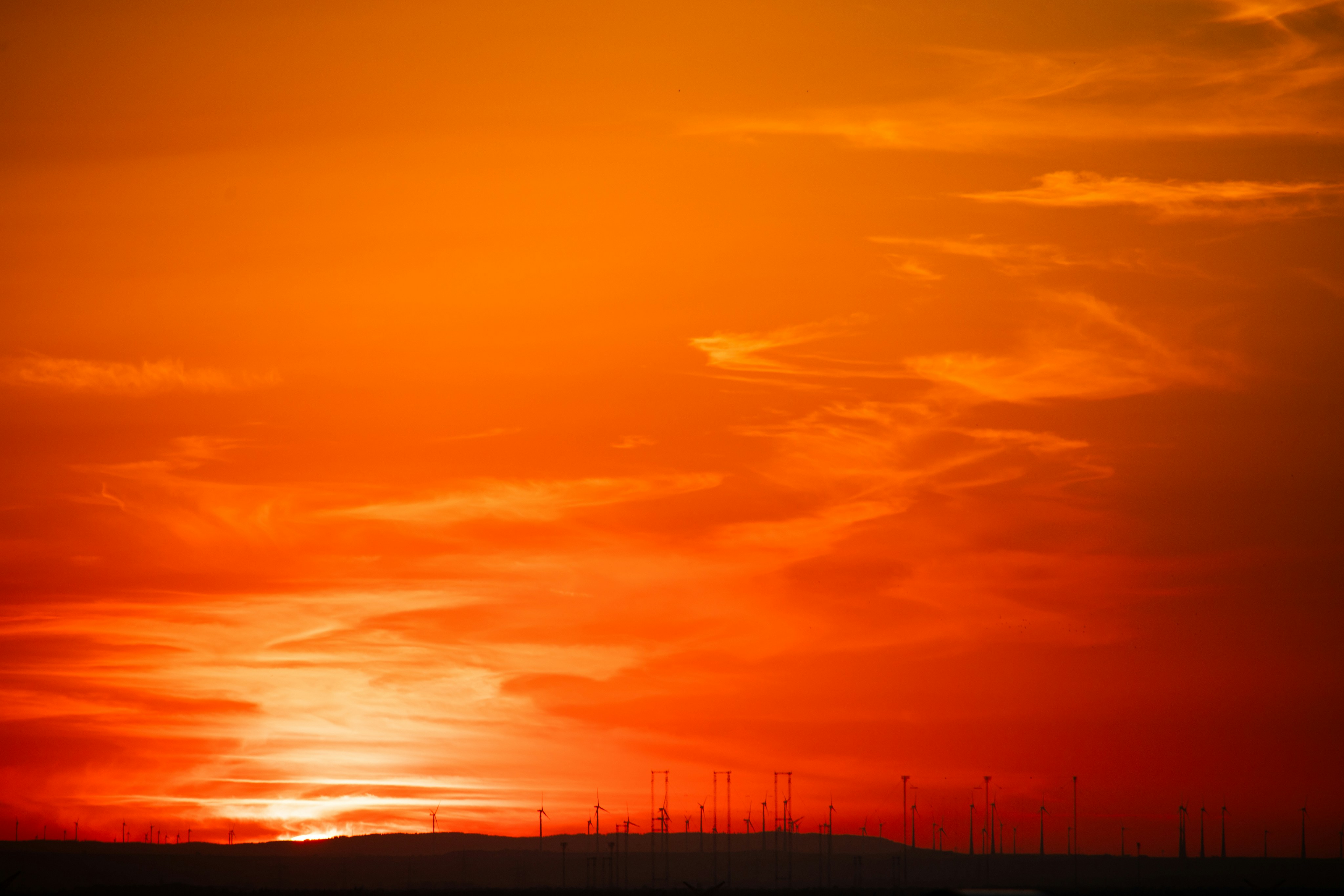 Crimson Horizon: Dusk Over a Silent Wind Farm