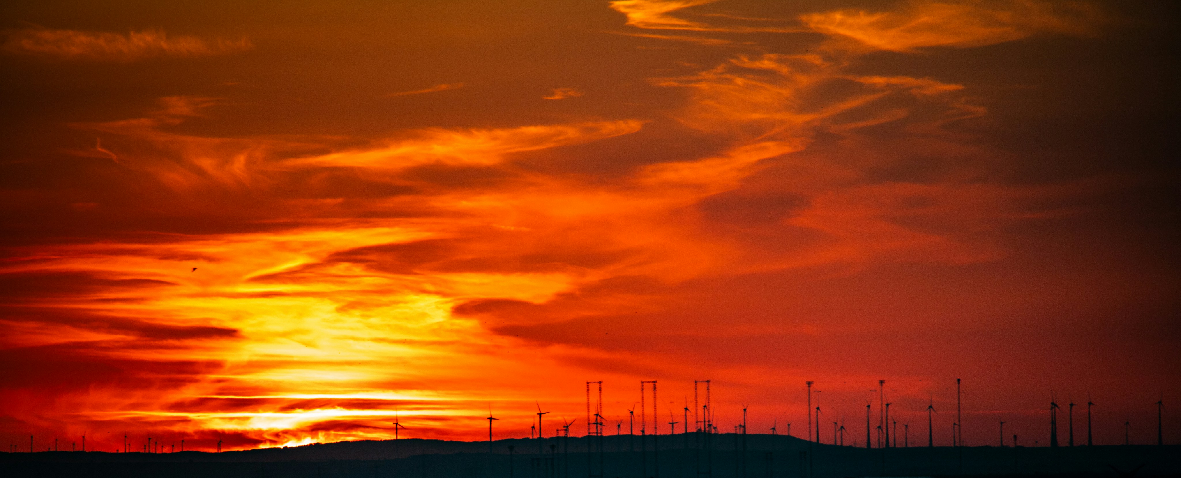 Low Horizon, Fiery Skies: A Silhouette of Antennas at Sunset