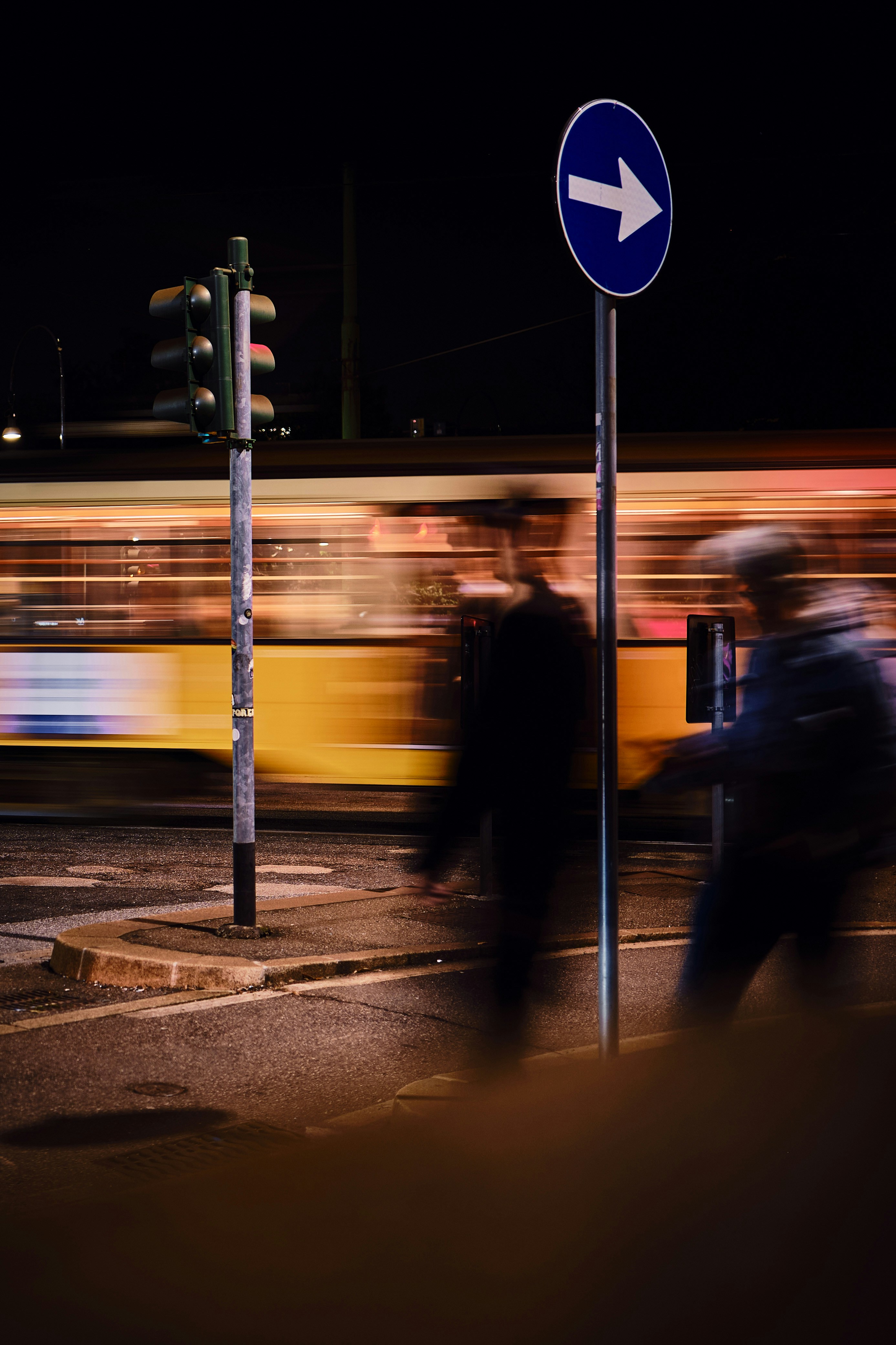Motion in the Night: A Blur of Passersby and a Neon Trajectory