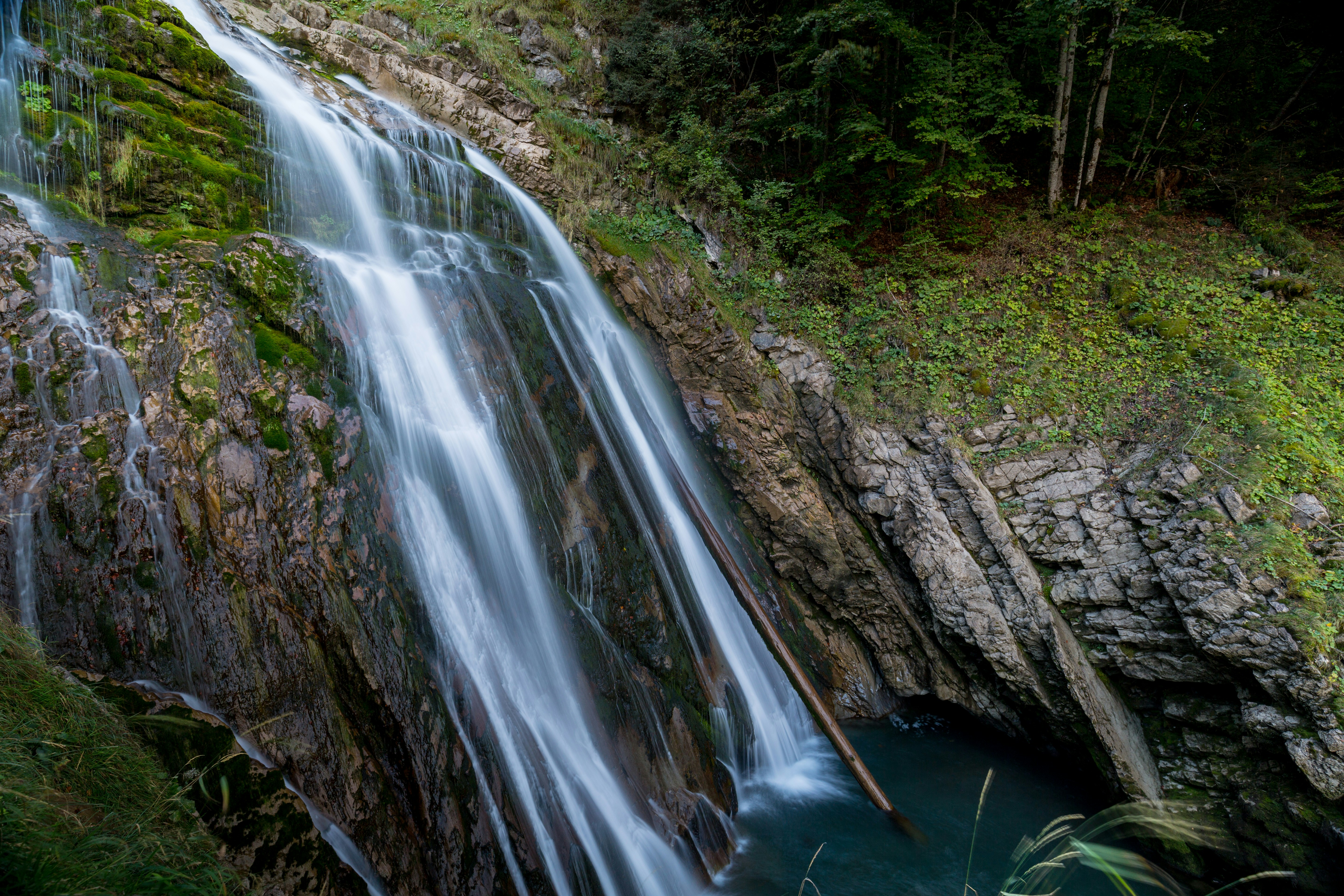 Emerald Veil: A Cascading River Between Mossy Cliffs