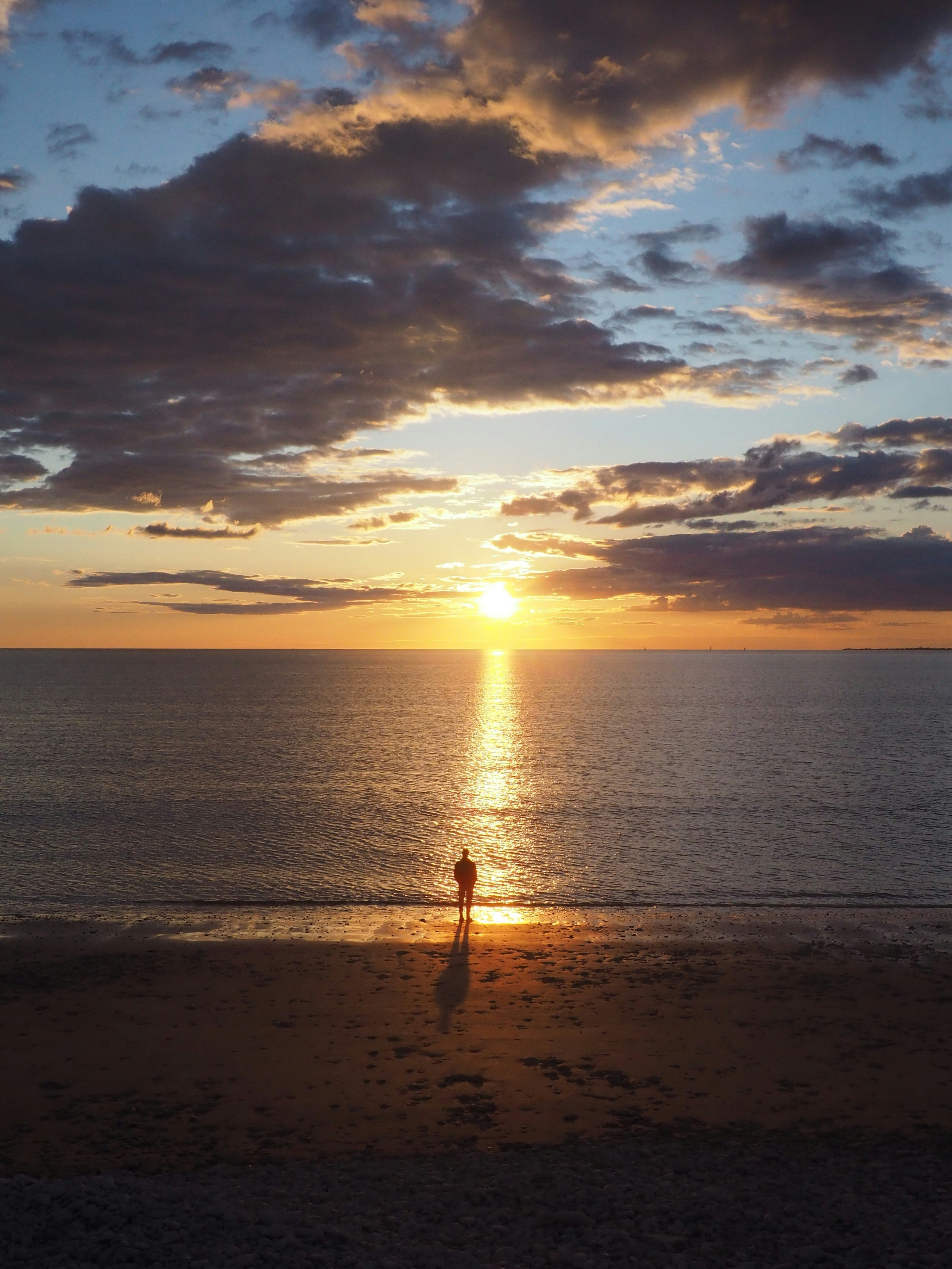 Sunset Solitude: The Silent Figure at the Shore