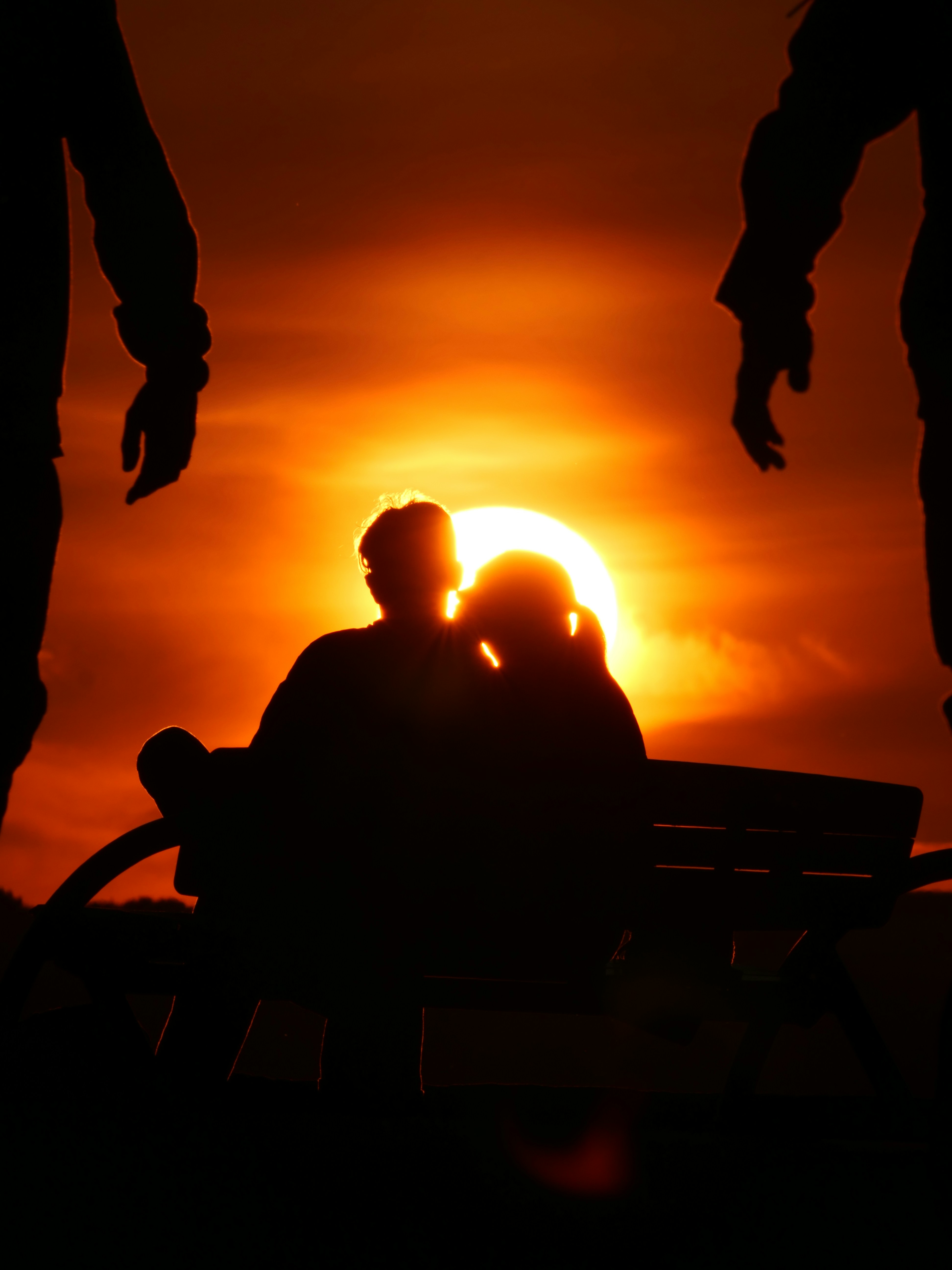 Sunset Silhouette on a Park Bench: Lovers Embrace at Dusk
