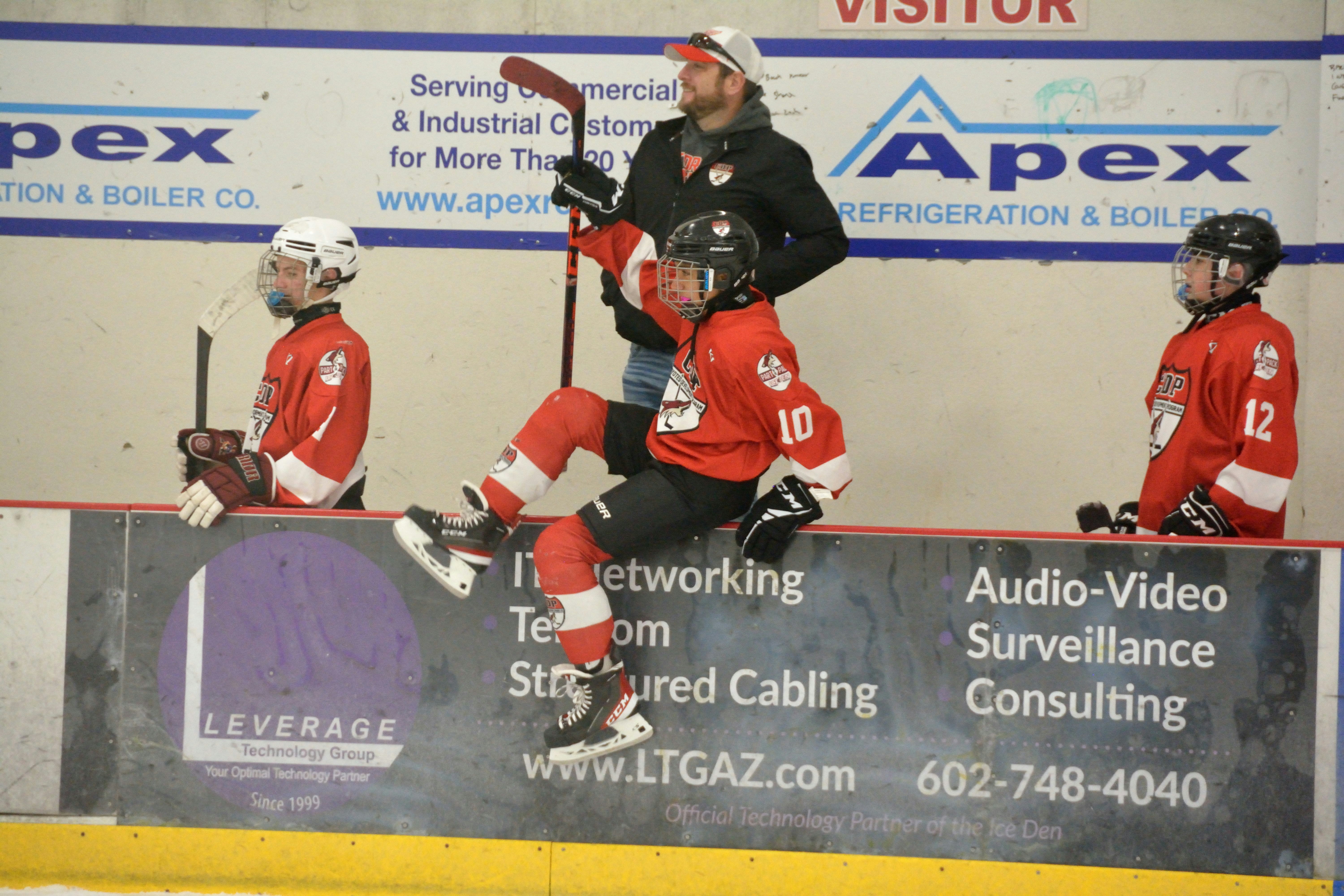 Mid-ice Lift: A Team Boss Surges Above the Boards as the Bench Celebrates