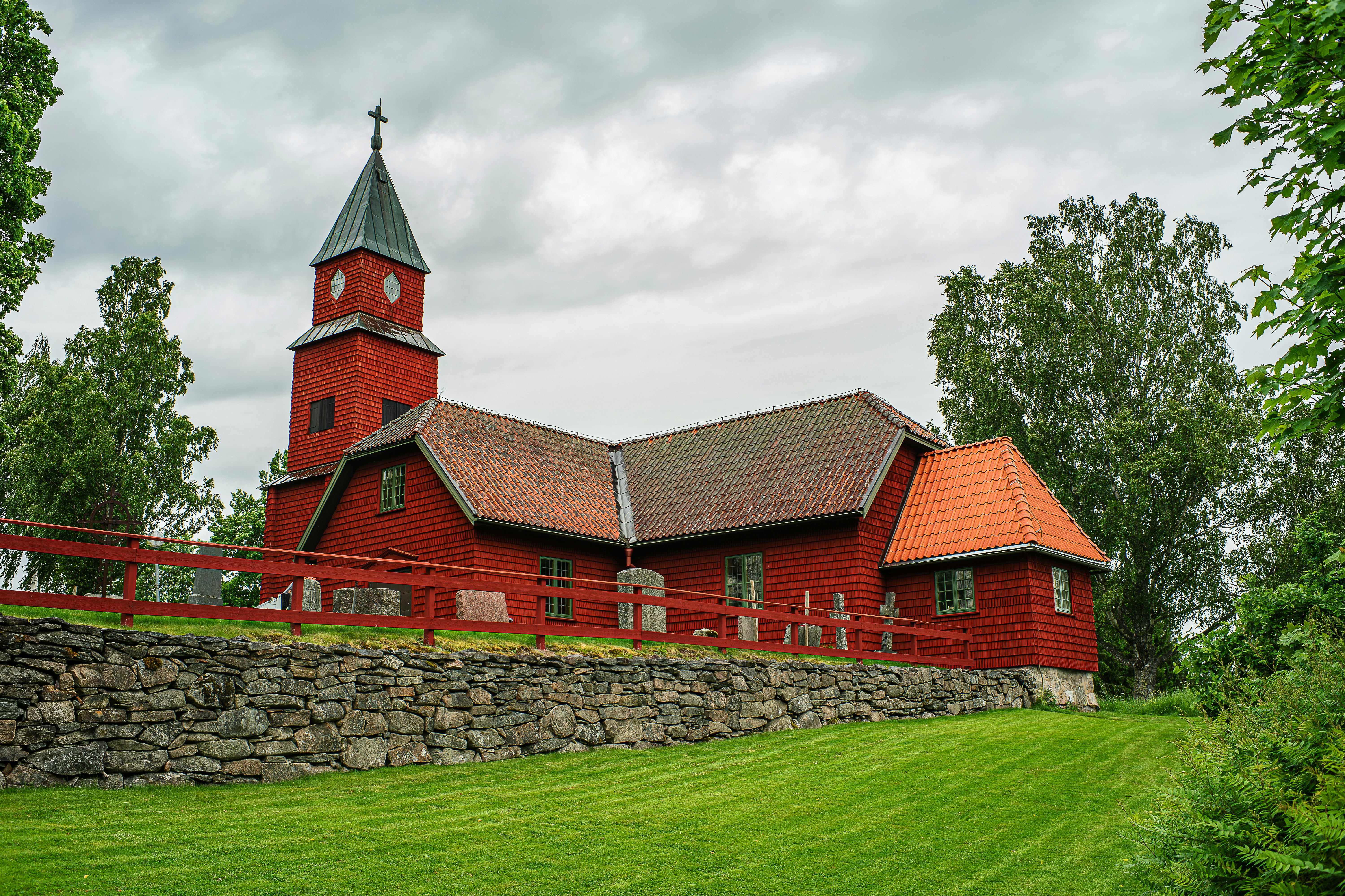 Red Chapel by the Stone Terrace under a Cloudy Sky