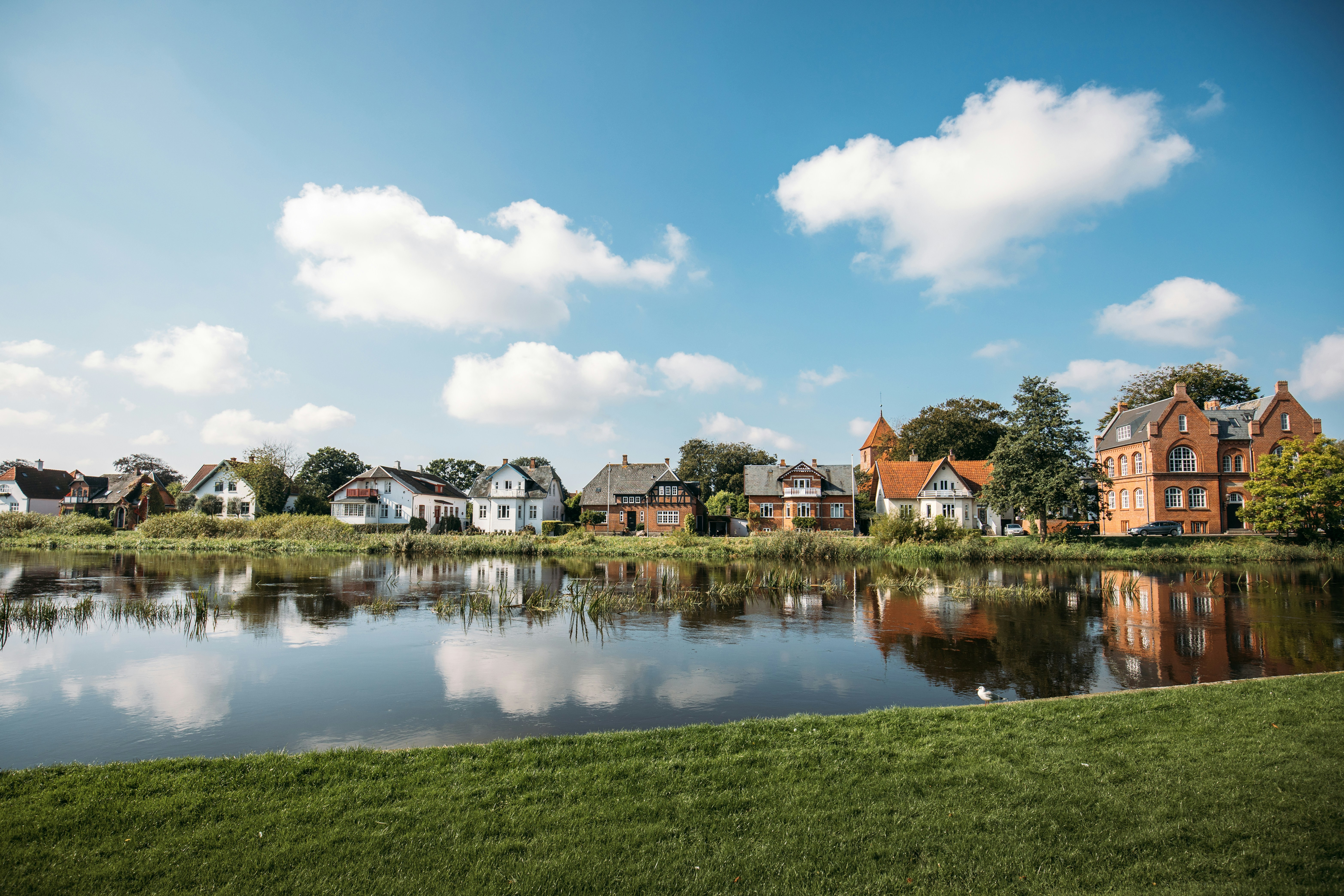 Quiet Riverside Row: Houses Dreamlike on the Reflective Water