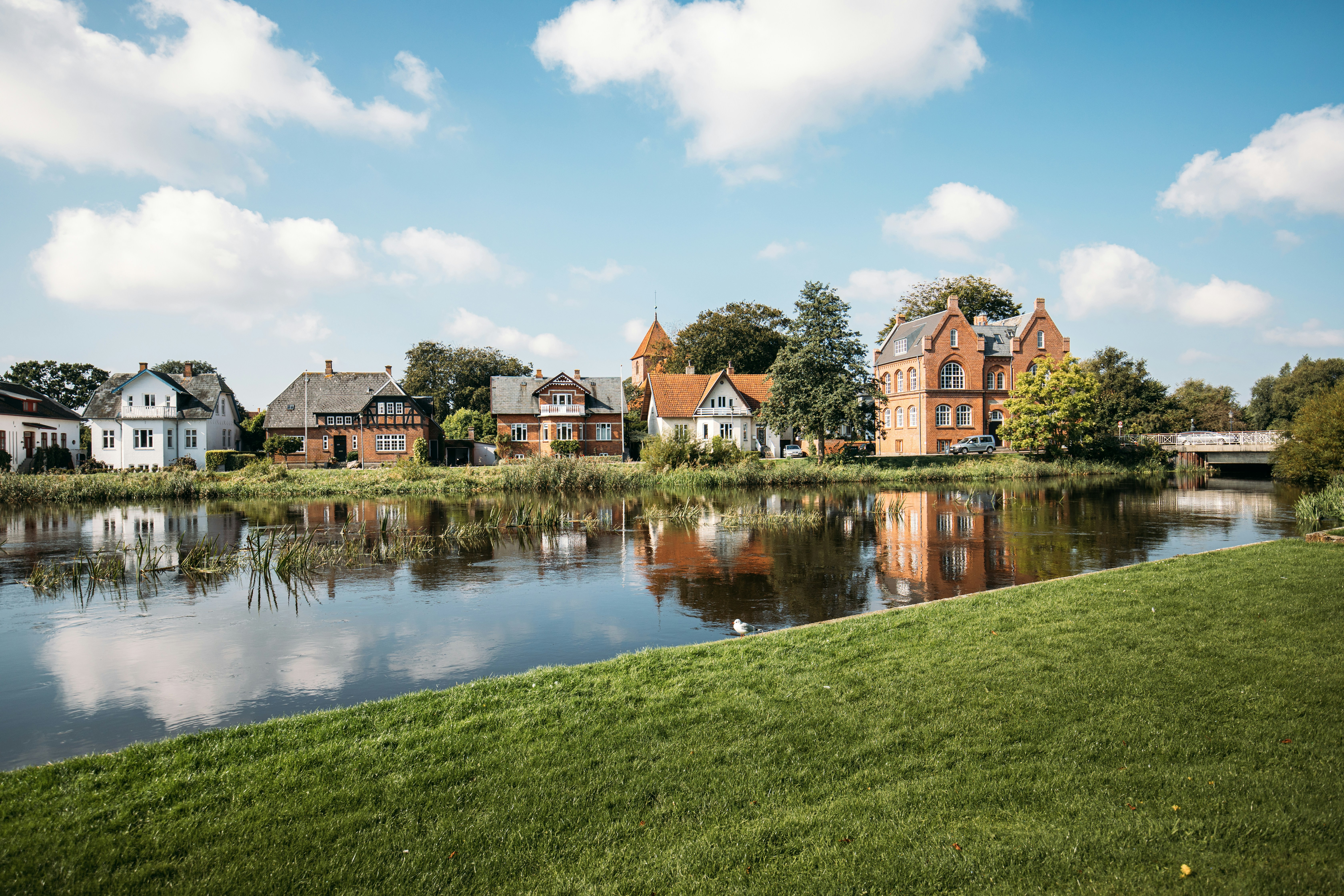 Pastoral Riverfront Row: Brick Townhouses Reflected in Calm Waters