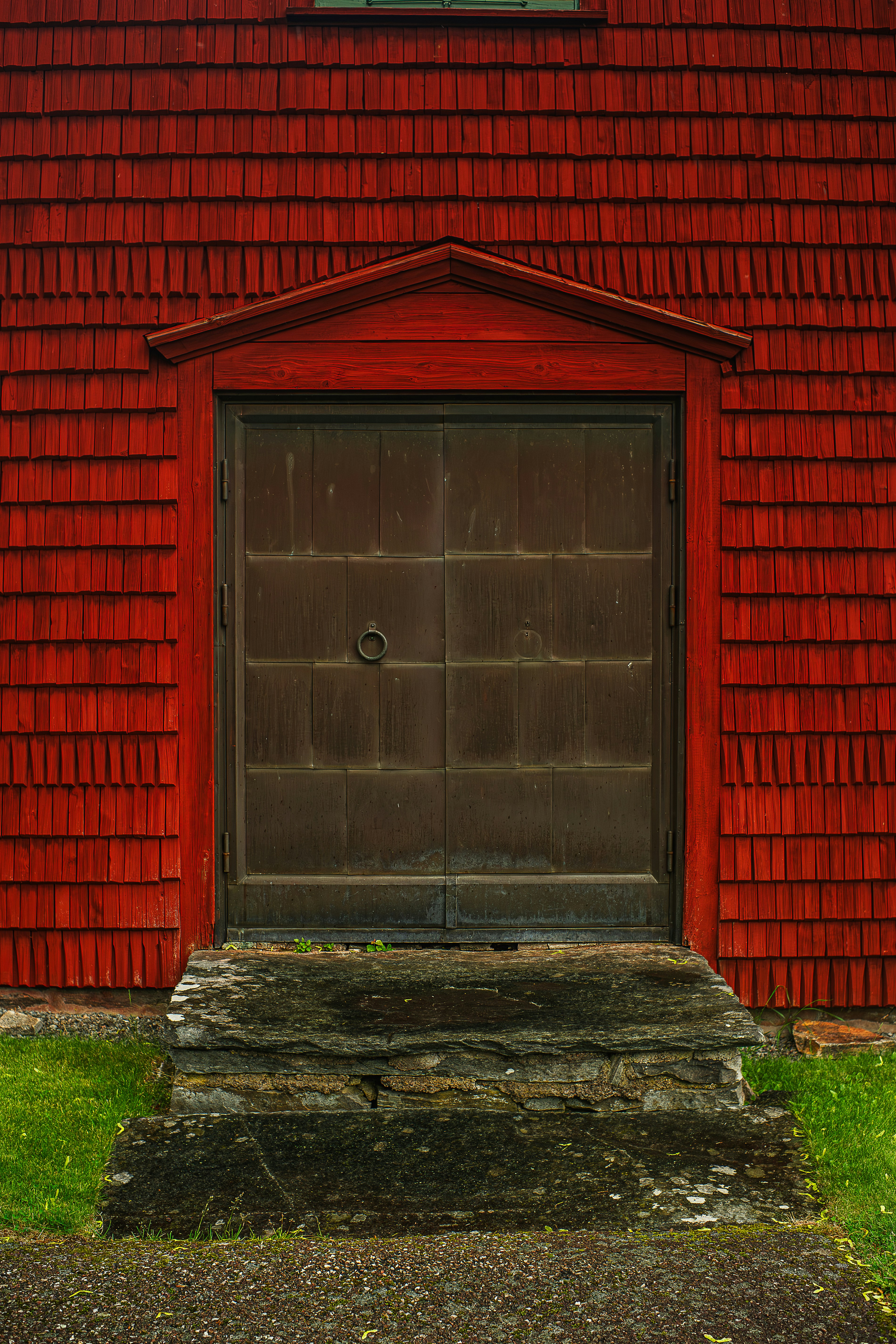 Red Barn Door: A Weathered Gate Beneath a Crimson Sash