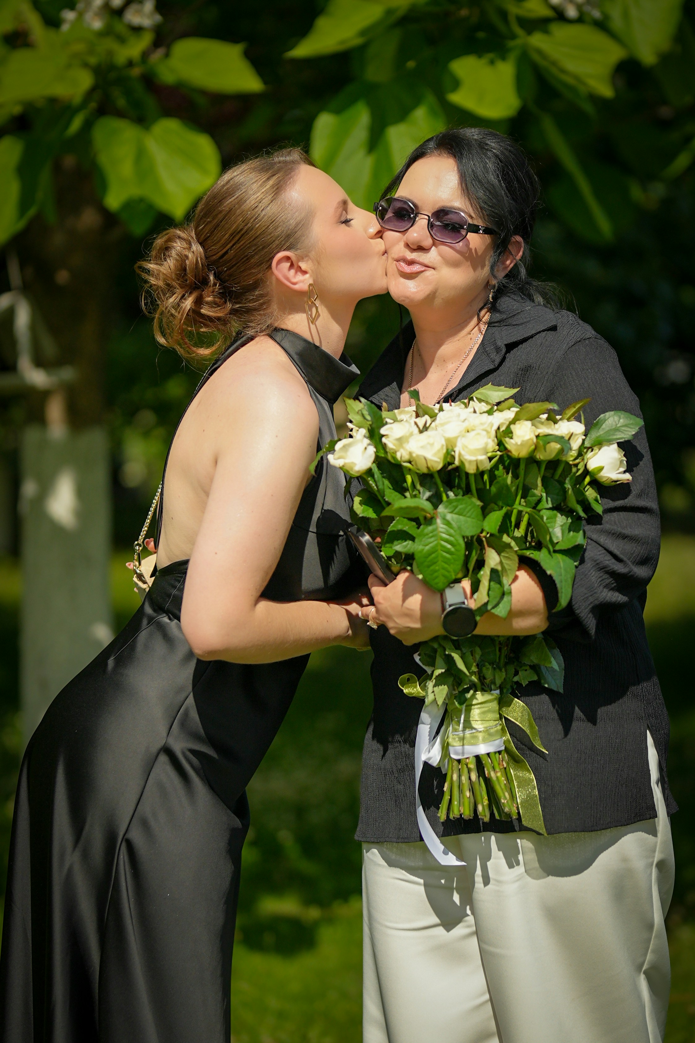 Kiss and Bouquet: A Moment of Celebration Between Friends