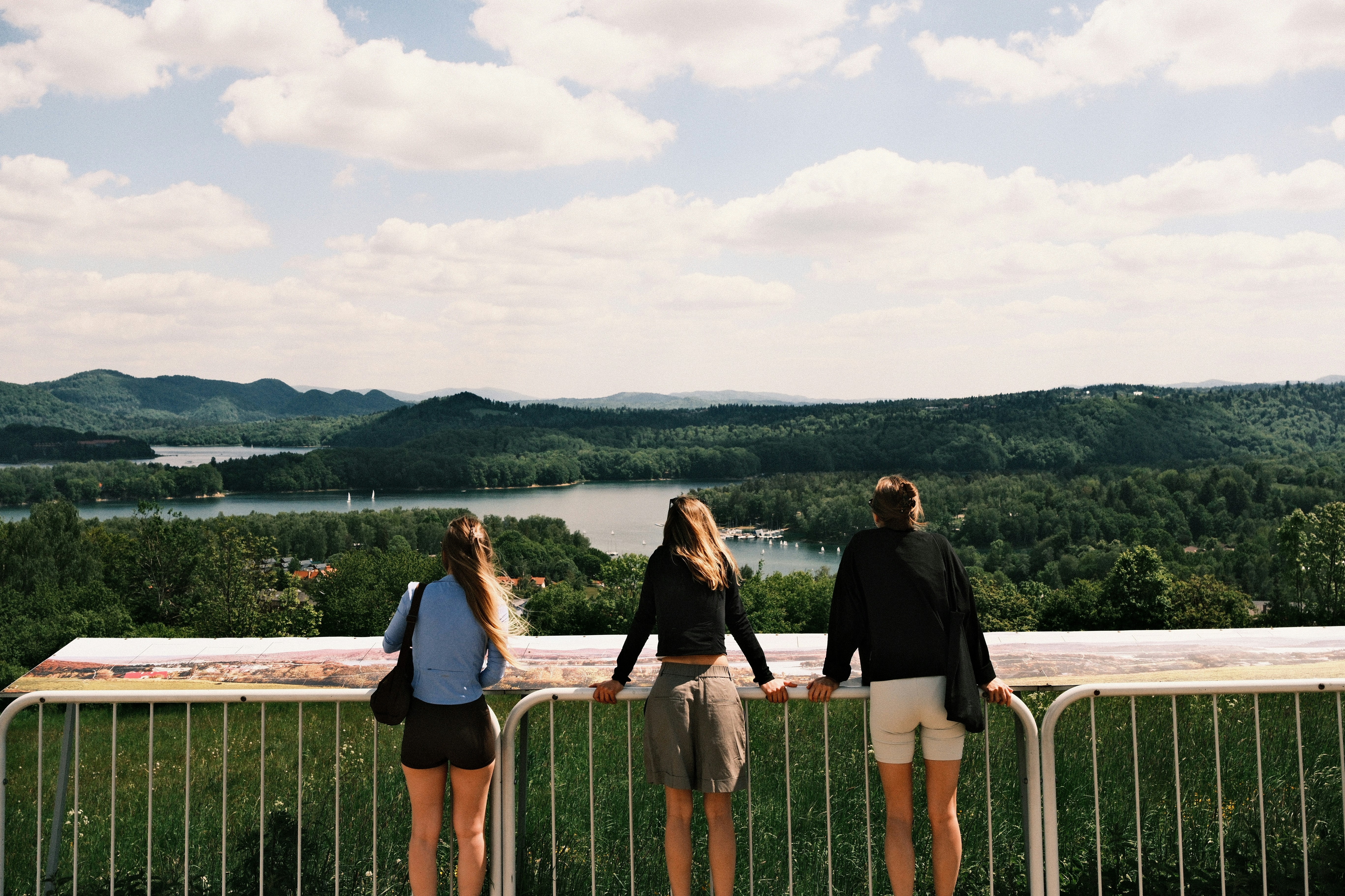 Three Observers At The Edge: A Vistascape With Tourists Overlooking a Valley