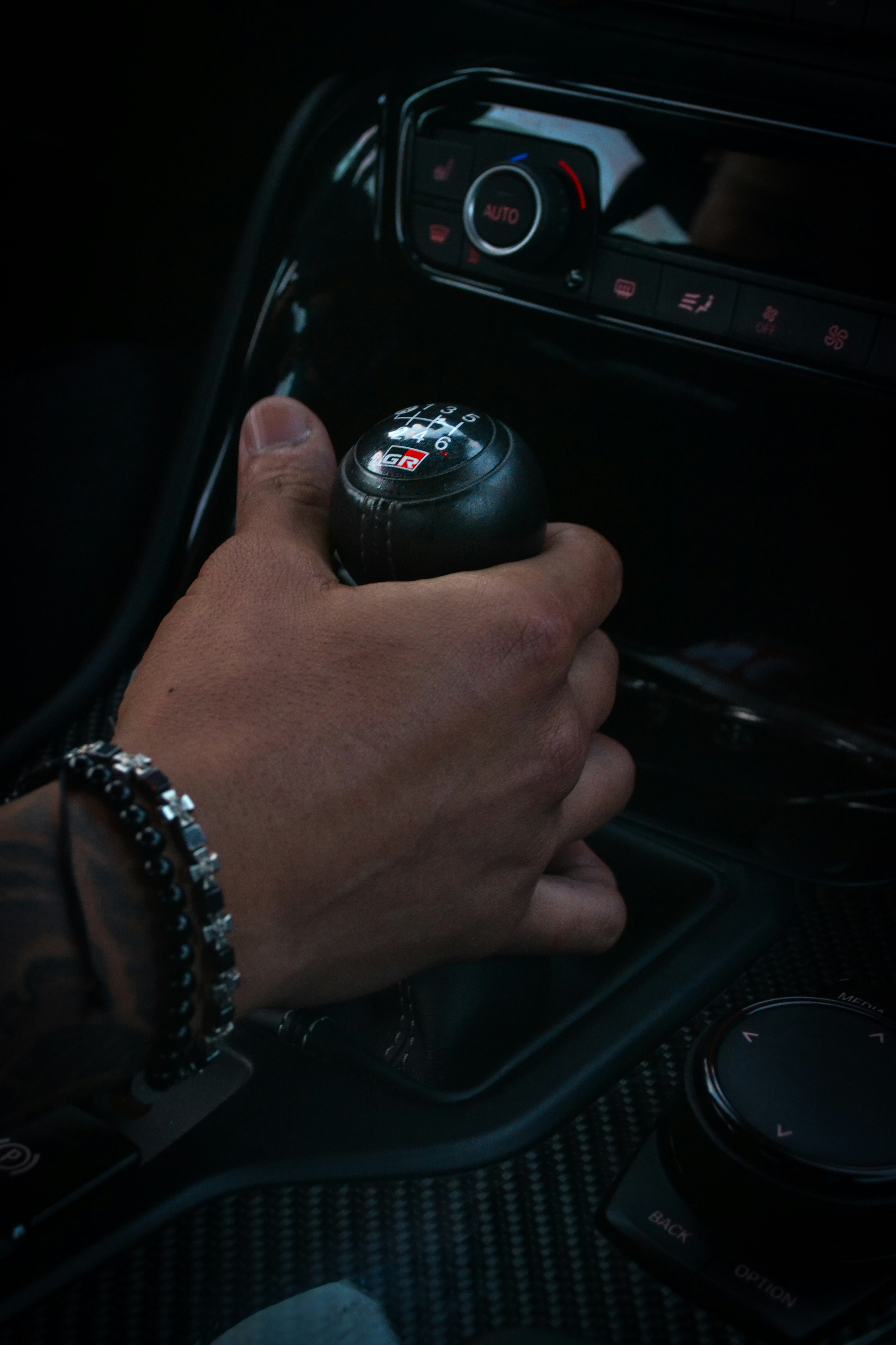 Manual Grip: The Driver’s Hand on the Gear in a Dim Car Cabin