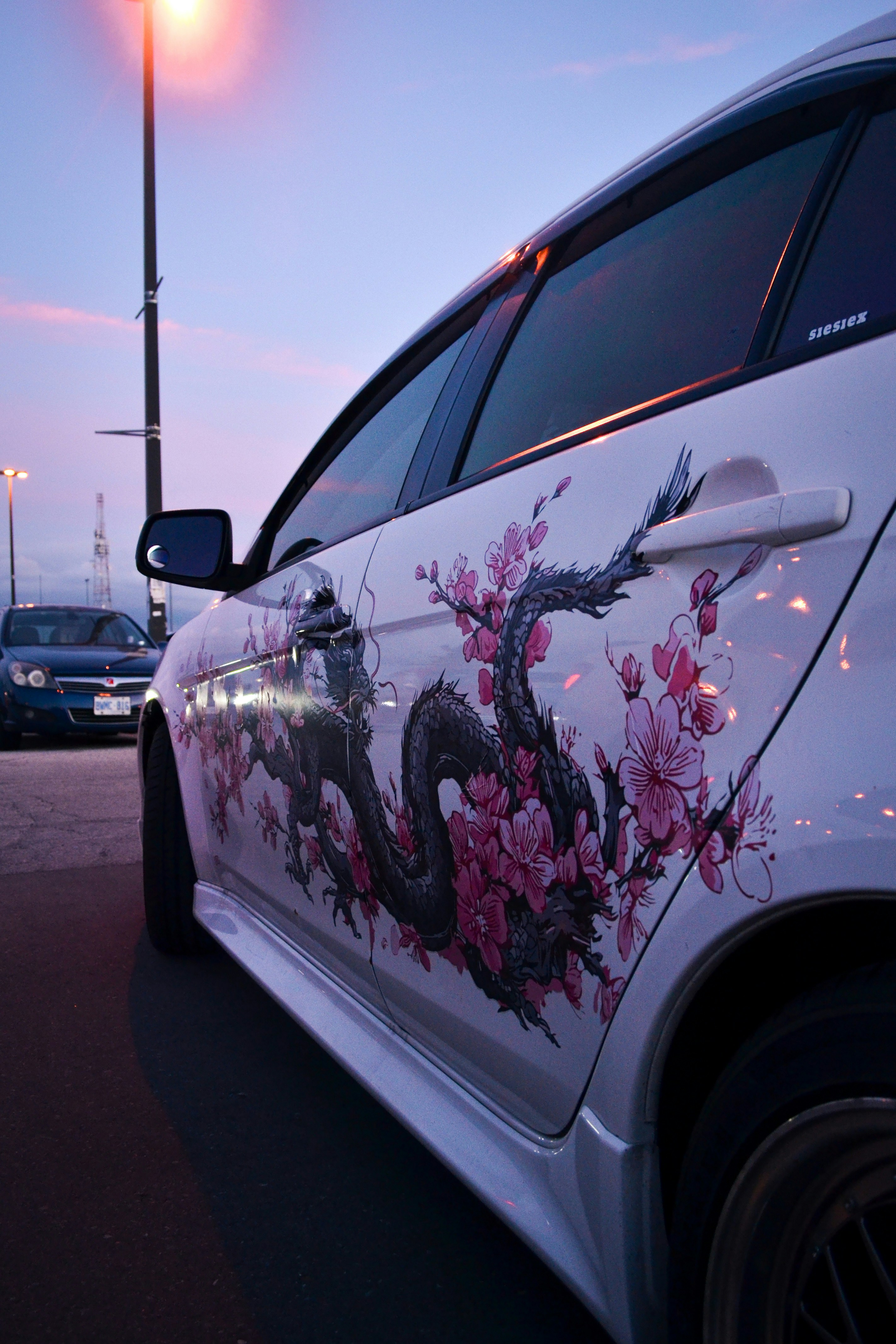 Dragon on the Side: Floral Sleeve Adorns a White Car