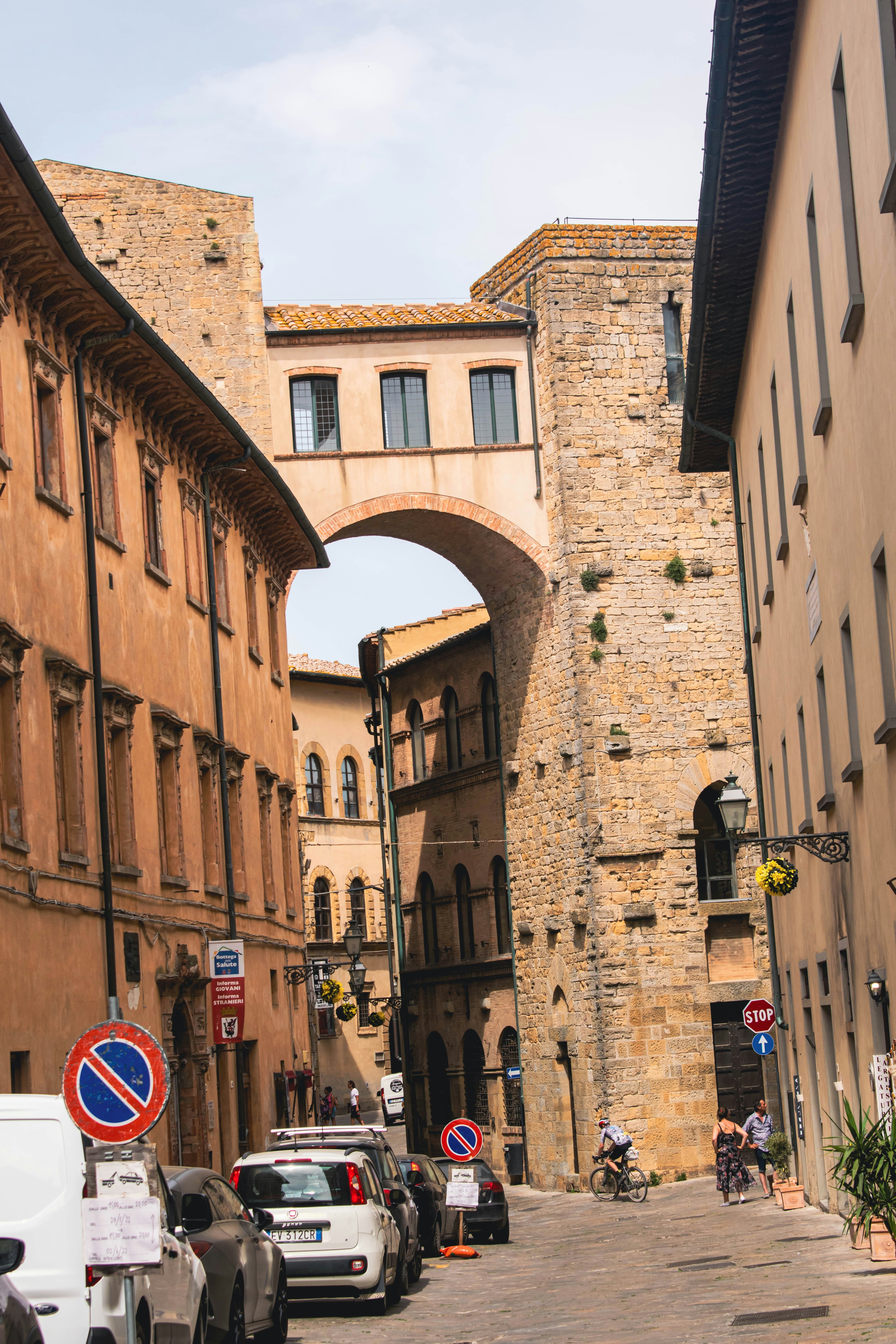 Stone Archway Over a Cobblestone Street Framed by Historic Town Buildings