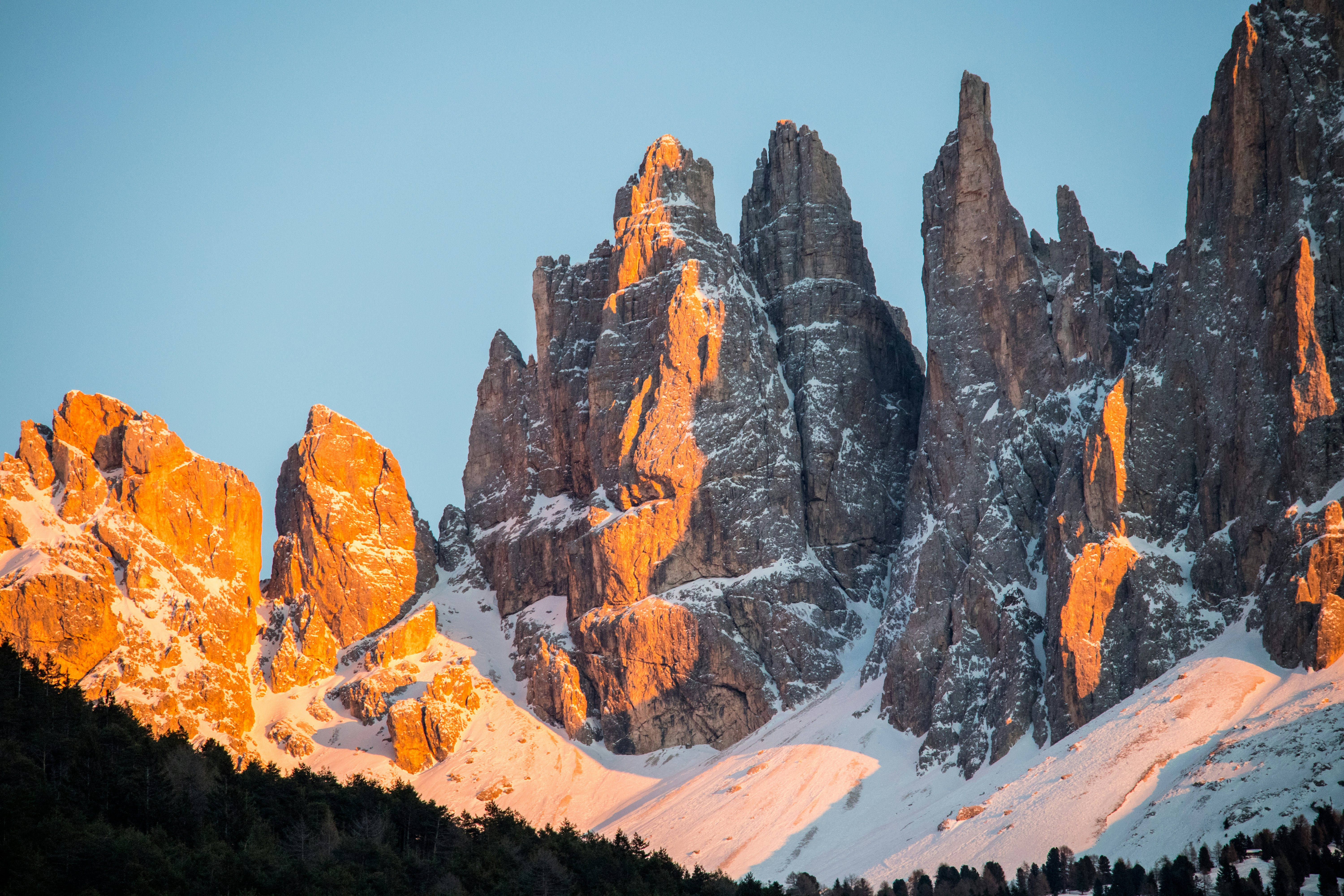 Sunlit Spires: Crimson Peaks Against a Clear Sky