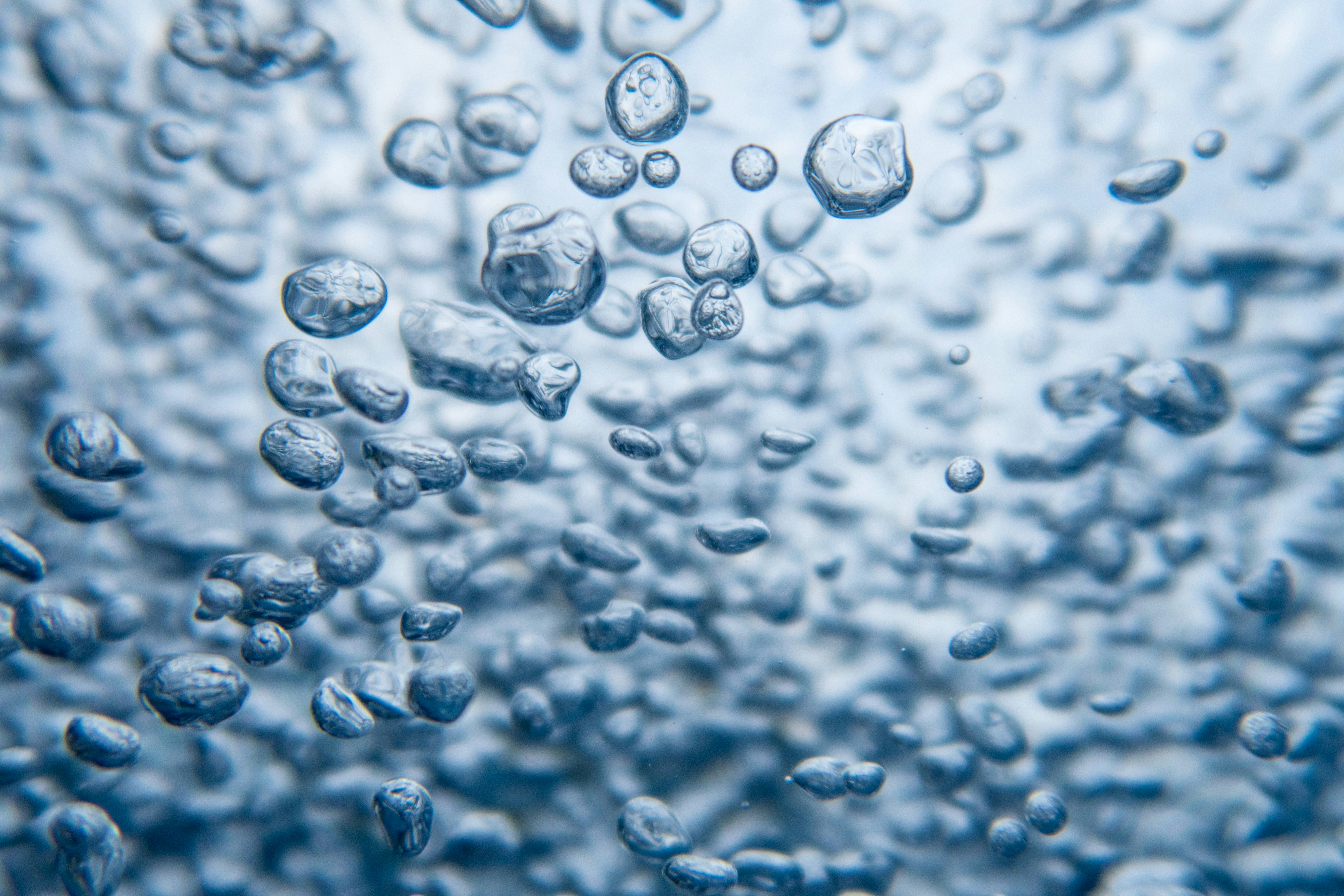 Submerged Symphony: Bubbles Floating Through Bright Blue Currents