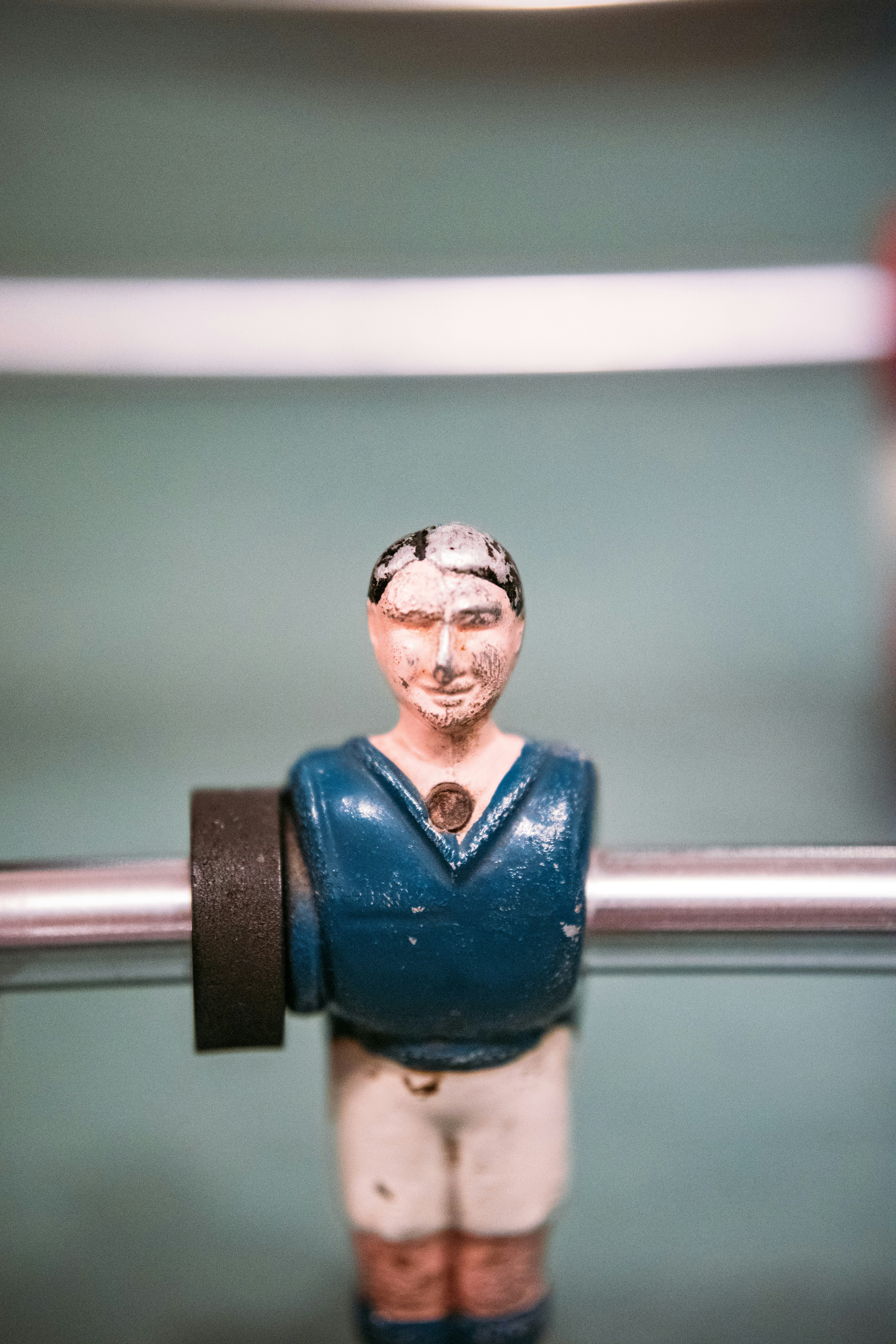 Tiny Foosball Figure on a Rod: A Portrait in Blur and Blue