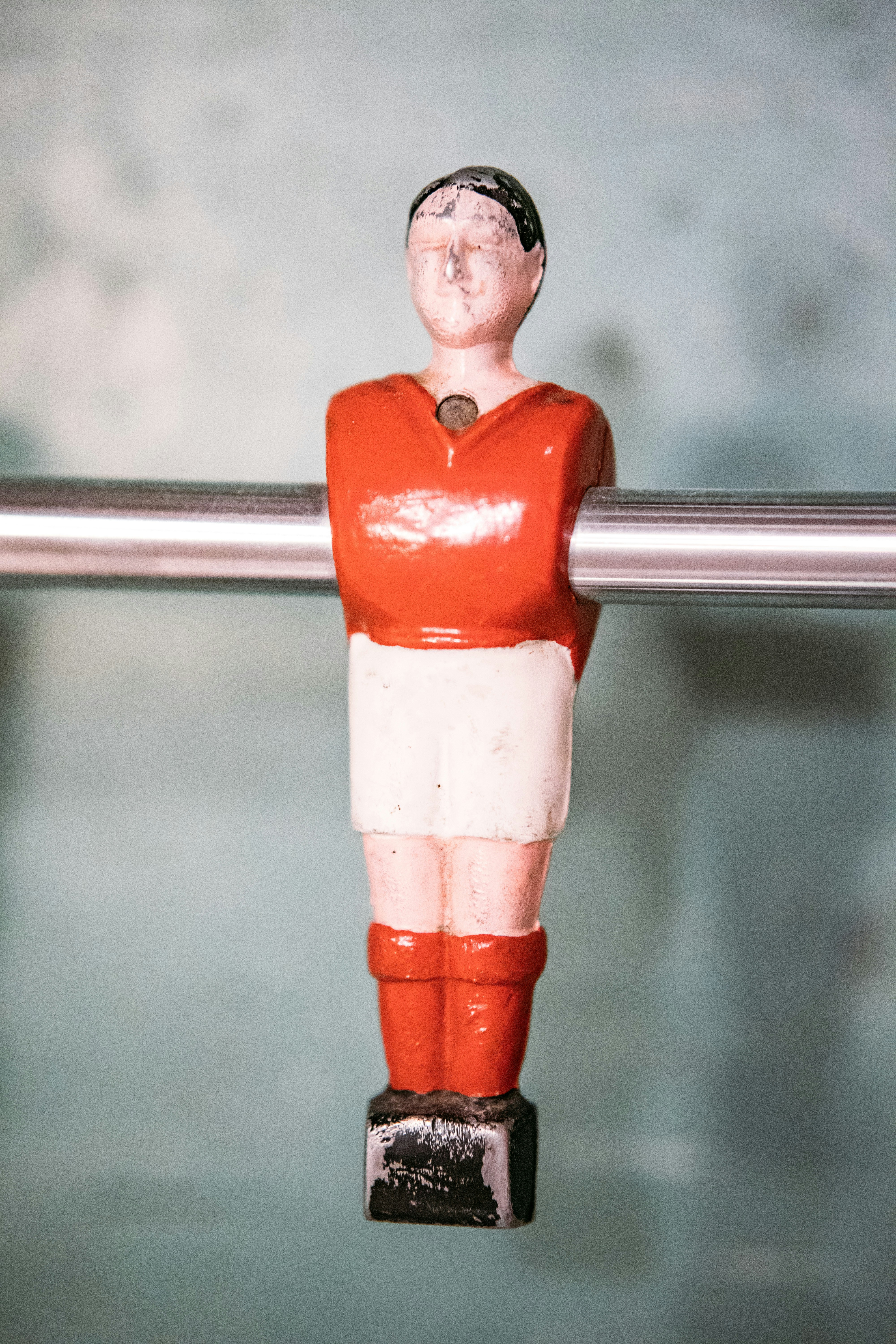 Foosball Hero on a Rod: A Tiny Figure Anchored by Metal Rails