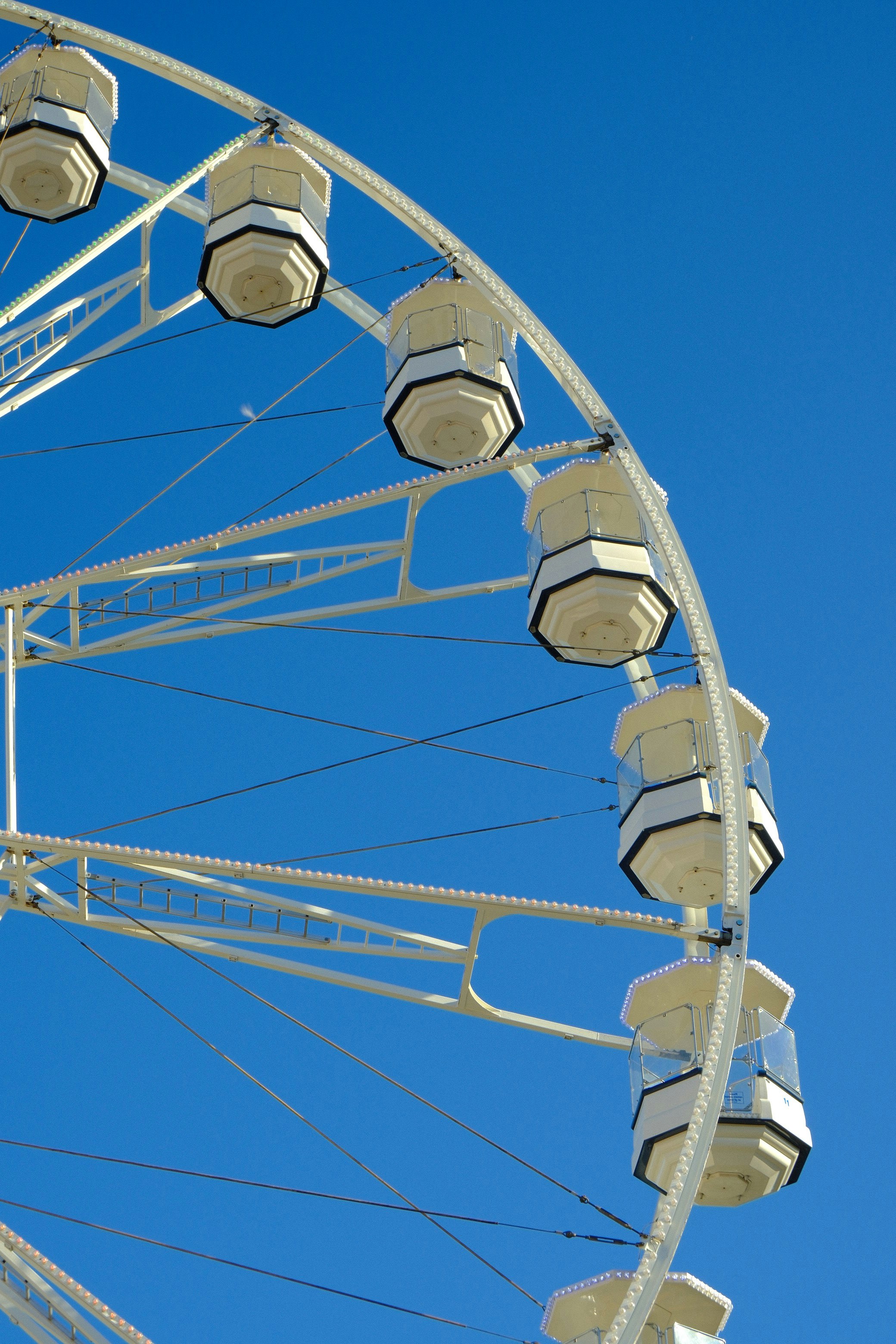 Circular Gateway: A Ferris Wheel Turns Against a Clear Blue