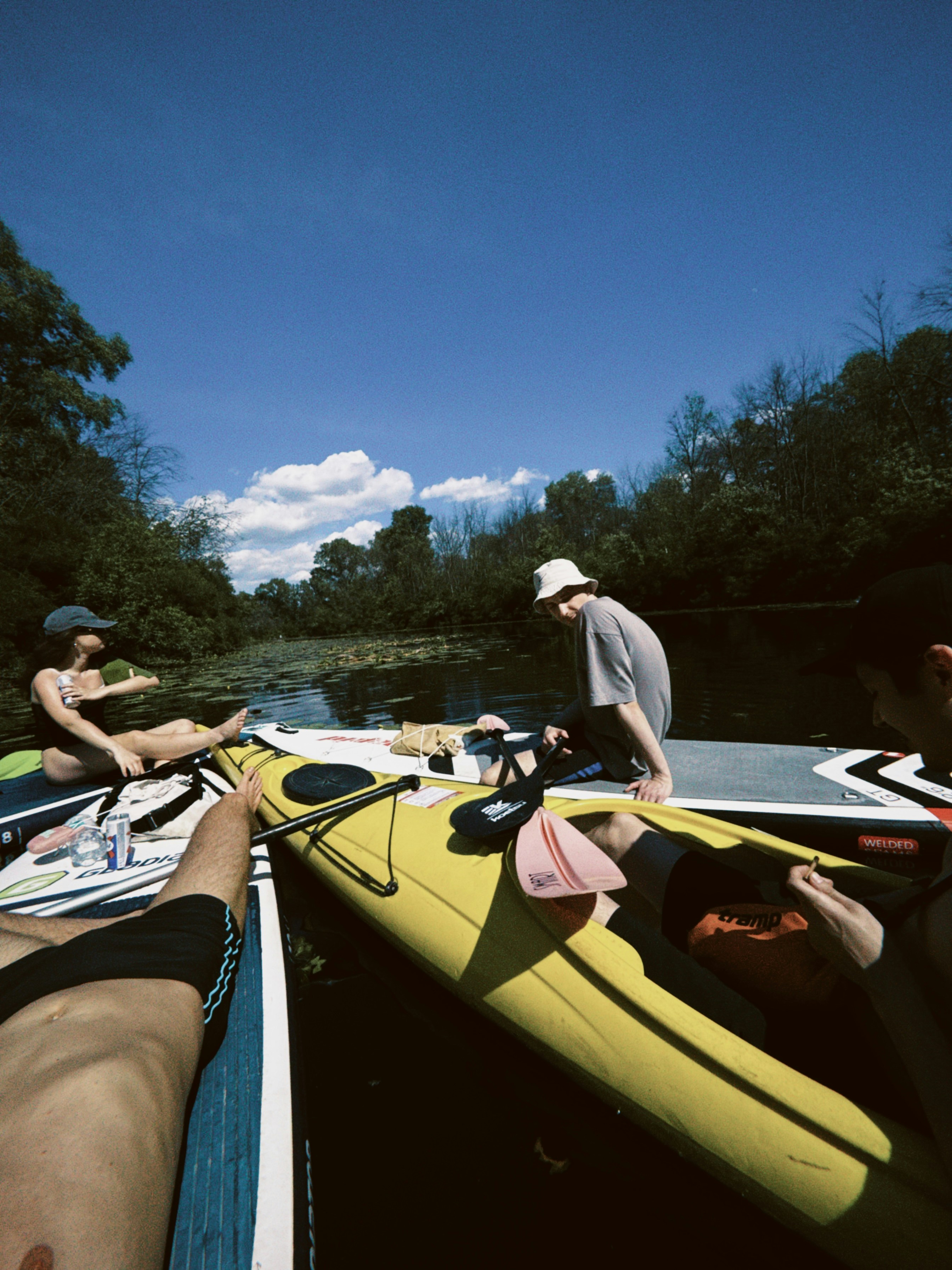 Circle of Paddles: A Sunlit River Group on Yellow Kayak